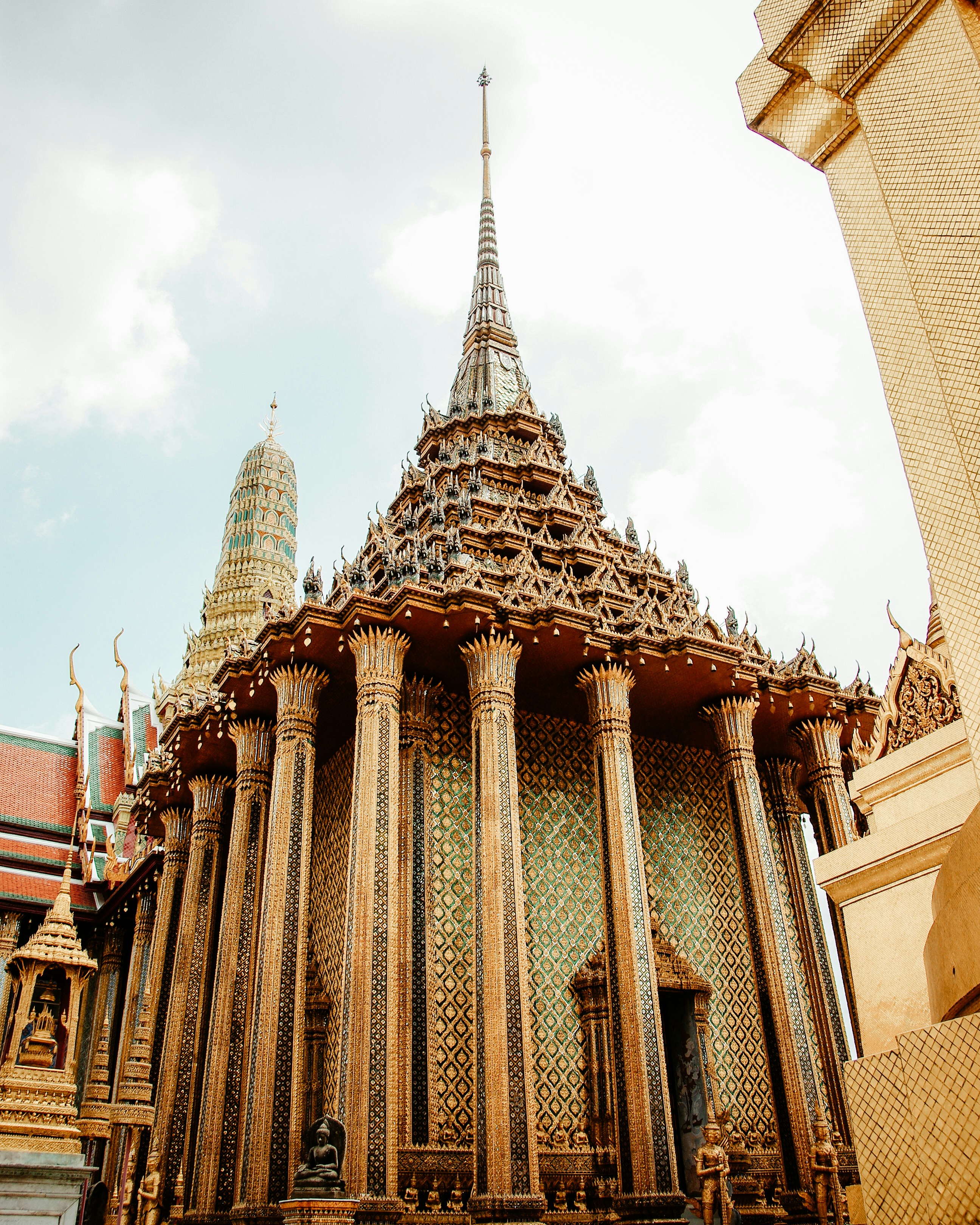 Sunlit Spire and Mosaic Facade: A Thai Temple in Golden Noon Light