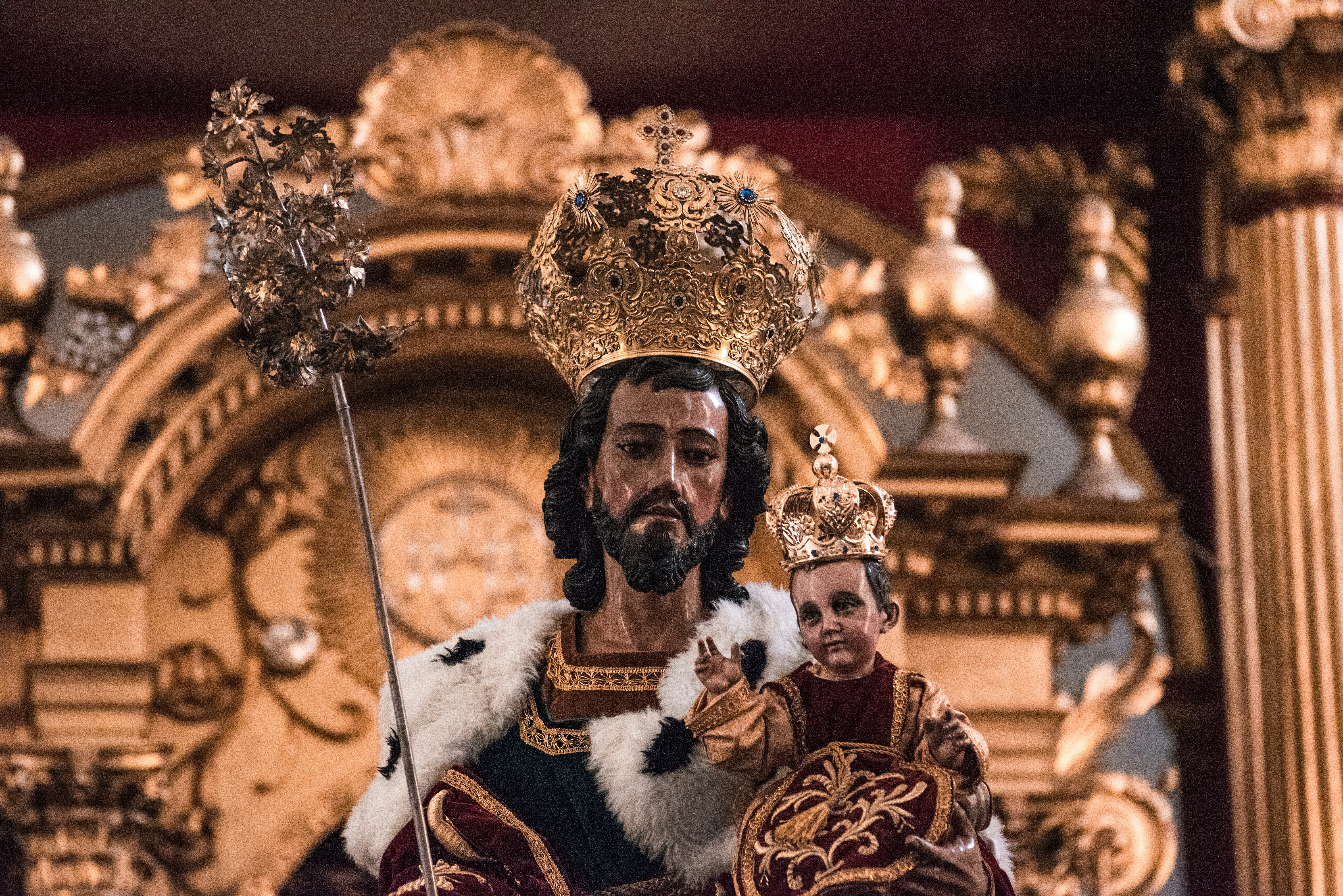 Elaborate gold and white religious statue adorned with crowns and ornate detailing.