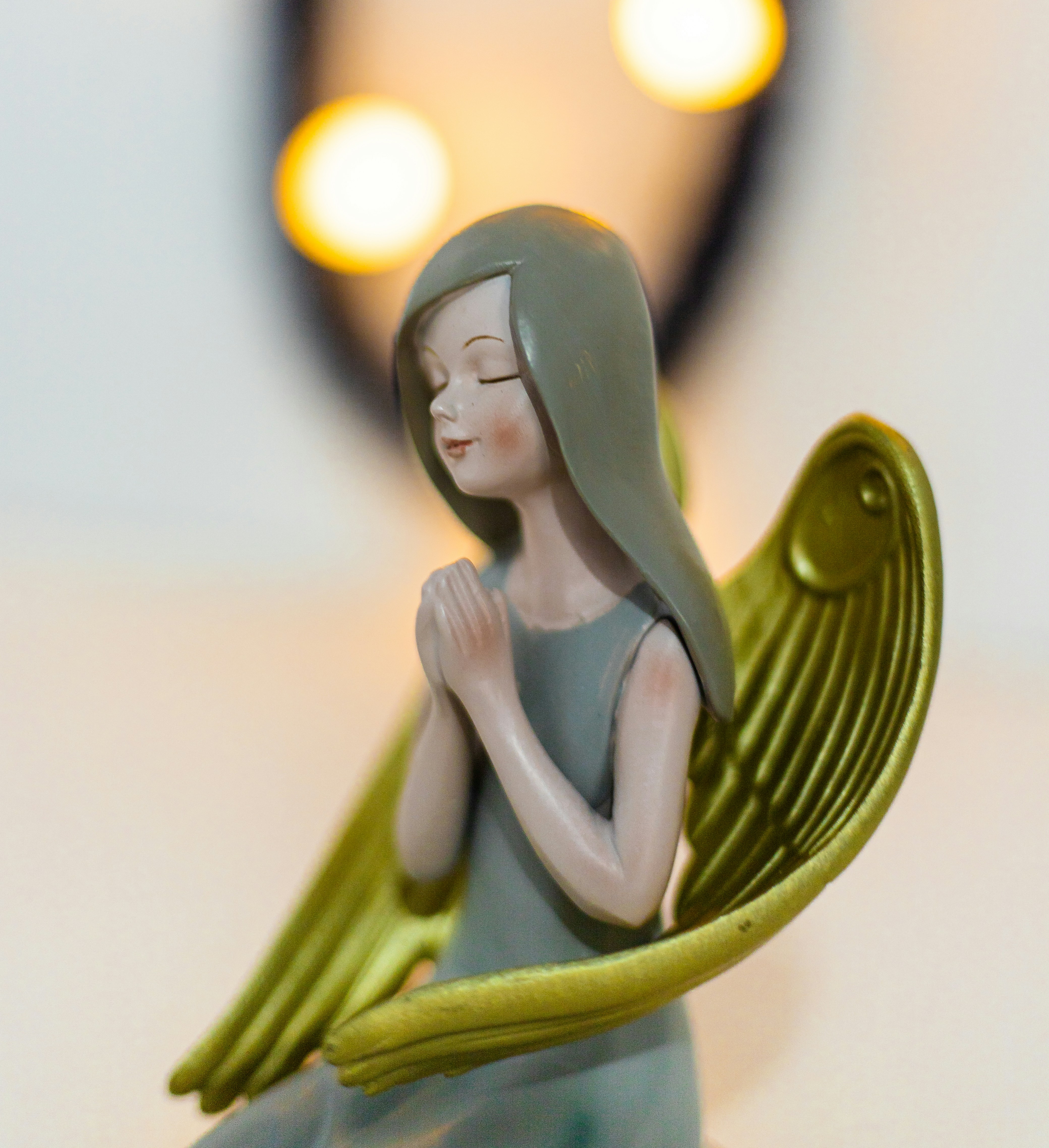 Whispered Prayers: a porcelain angel bathed in amber orbs