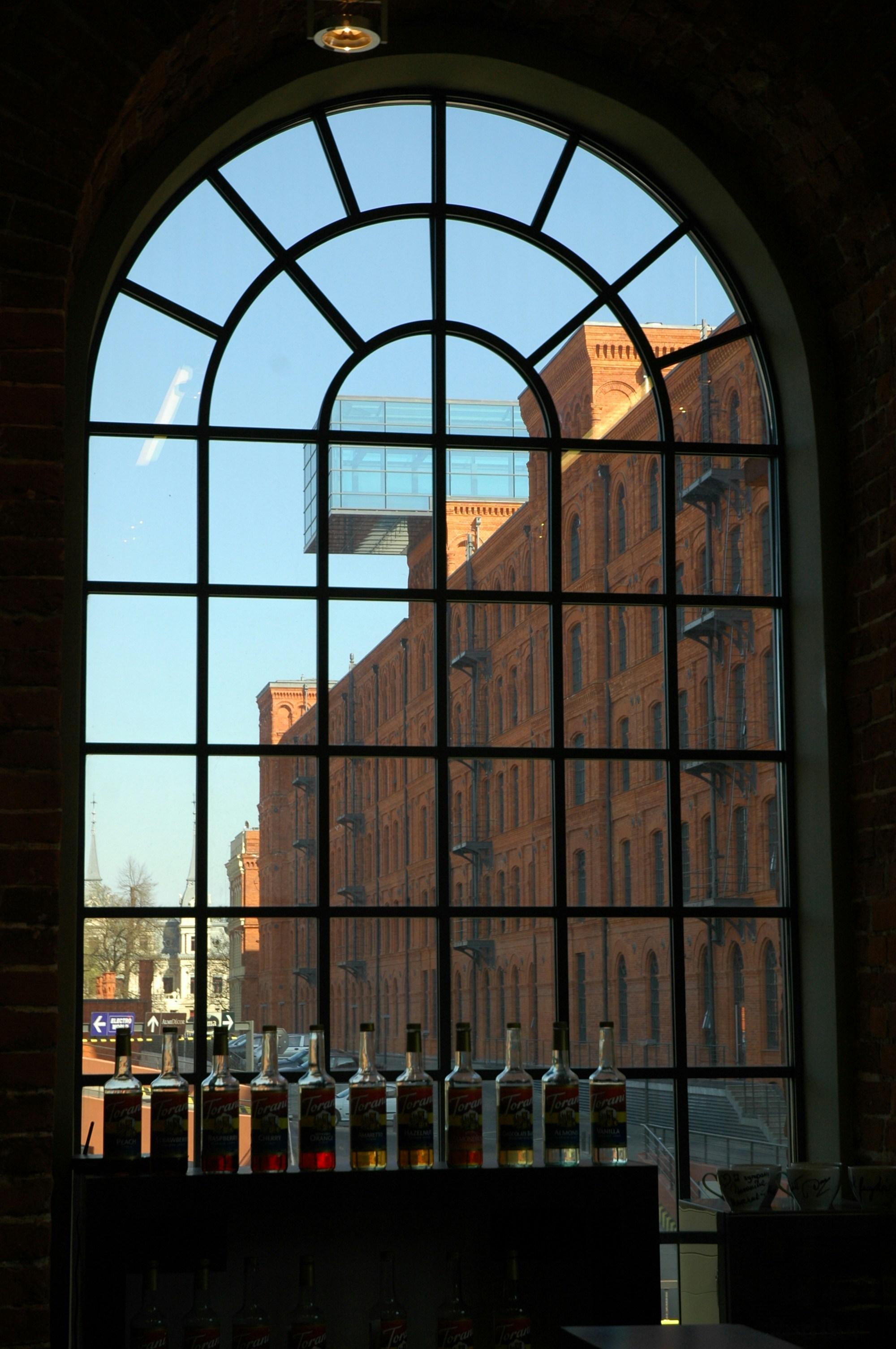 Sunlit Brick Corridor Through a Grid Window