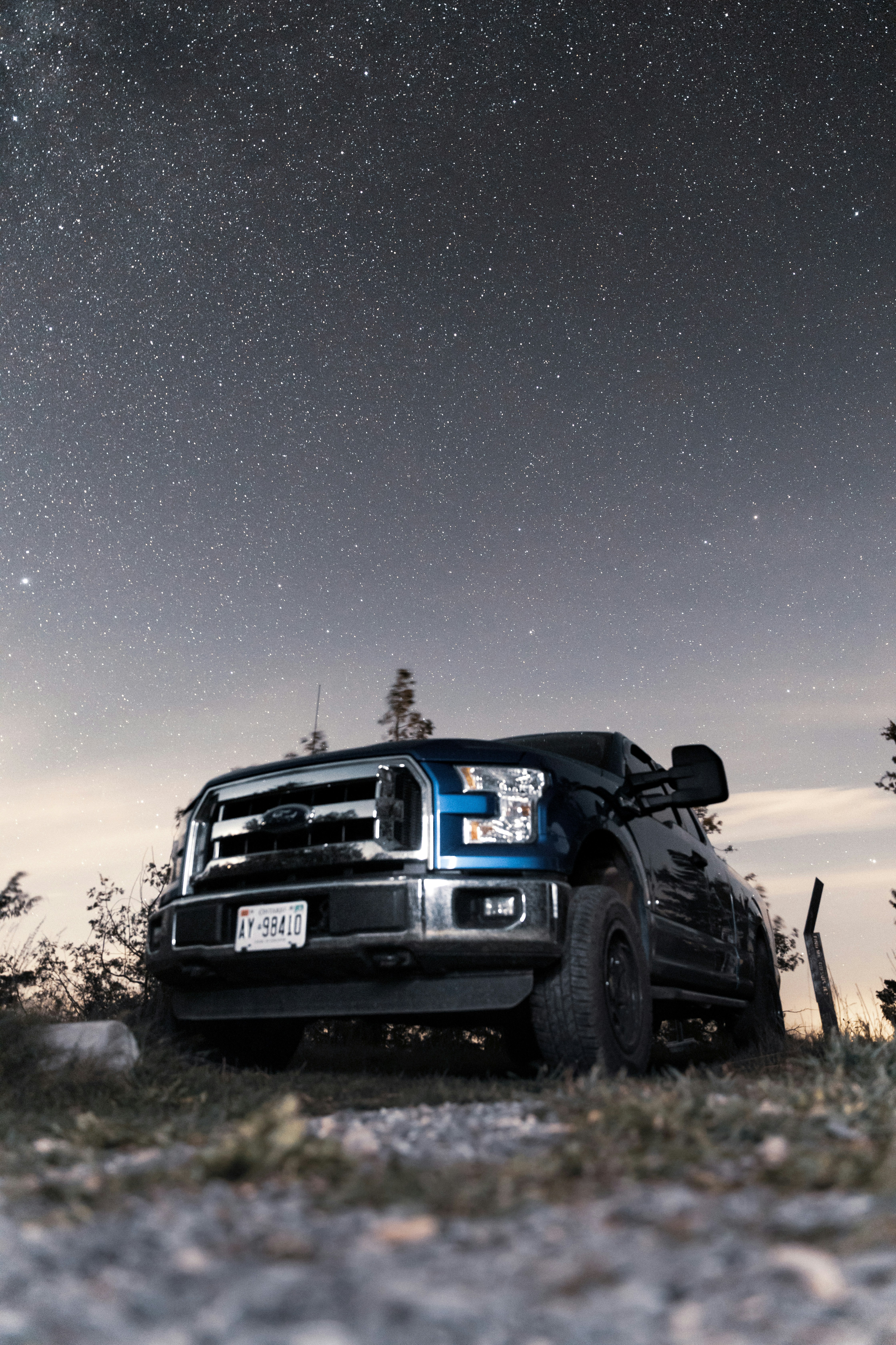 Low-Angle Midnight Standstill: Blue Pickup Beneath a Starfield