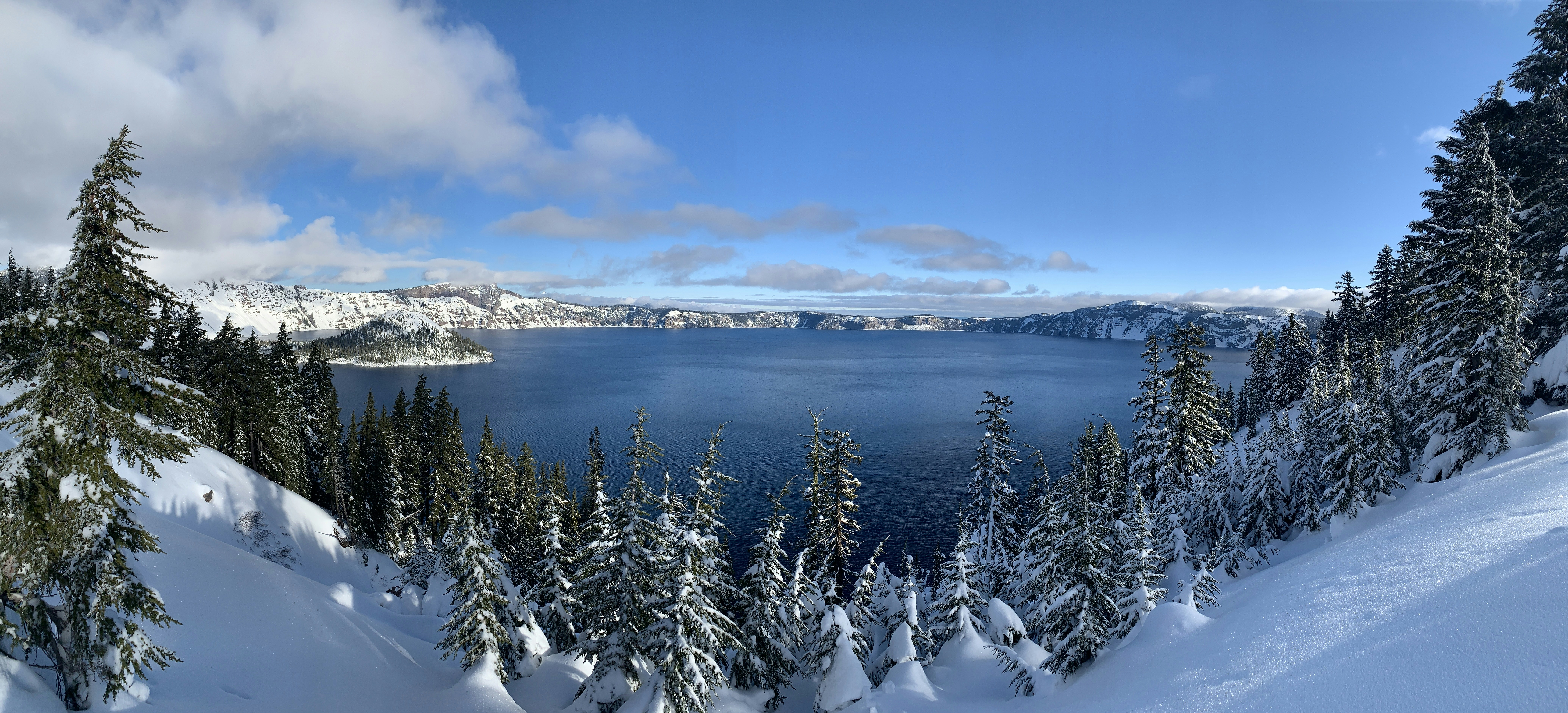 Snowbound Rim: A Panoramic Winter Vista Over a Deep Blue Lake