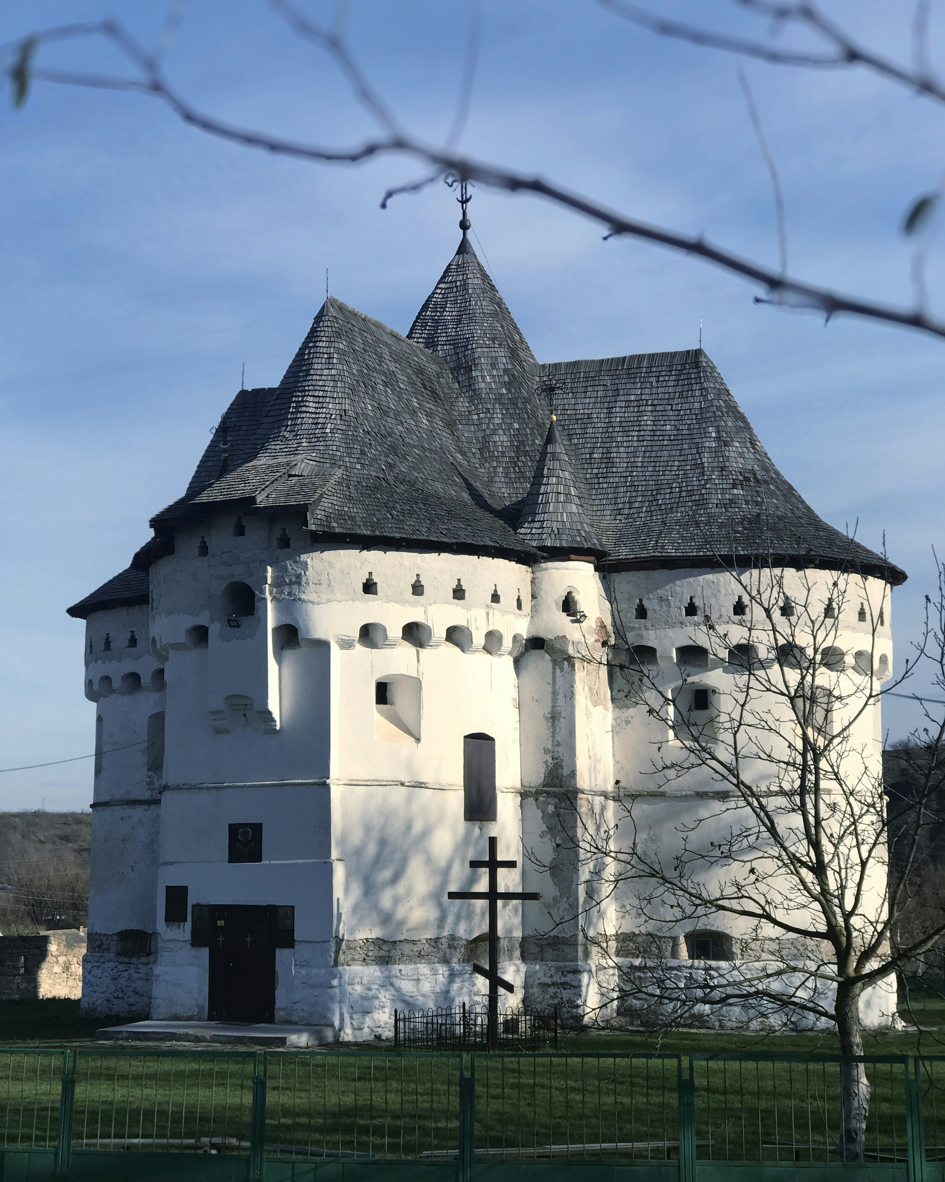 A historic fortress with unique architectural features, showcasing its rounded towers and intricate rooflines against a clear blue sky.