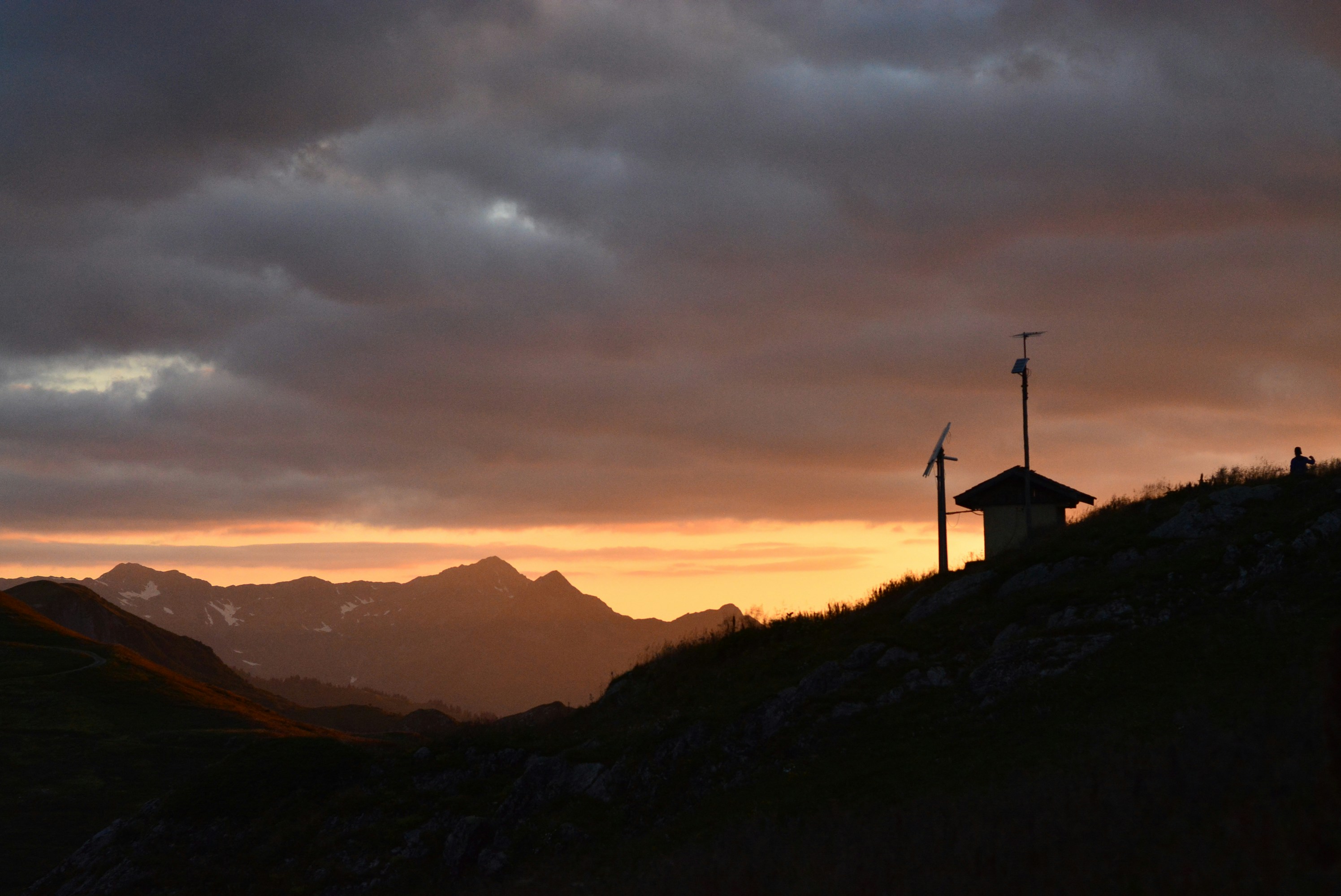 silhouette of wind turbines on mountain during sunset