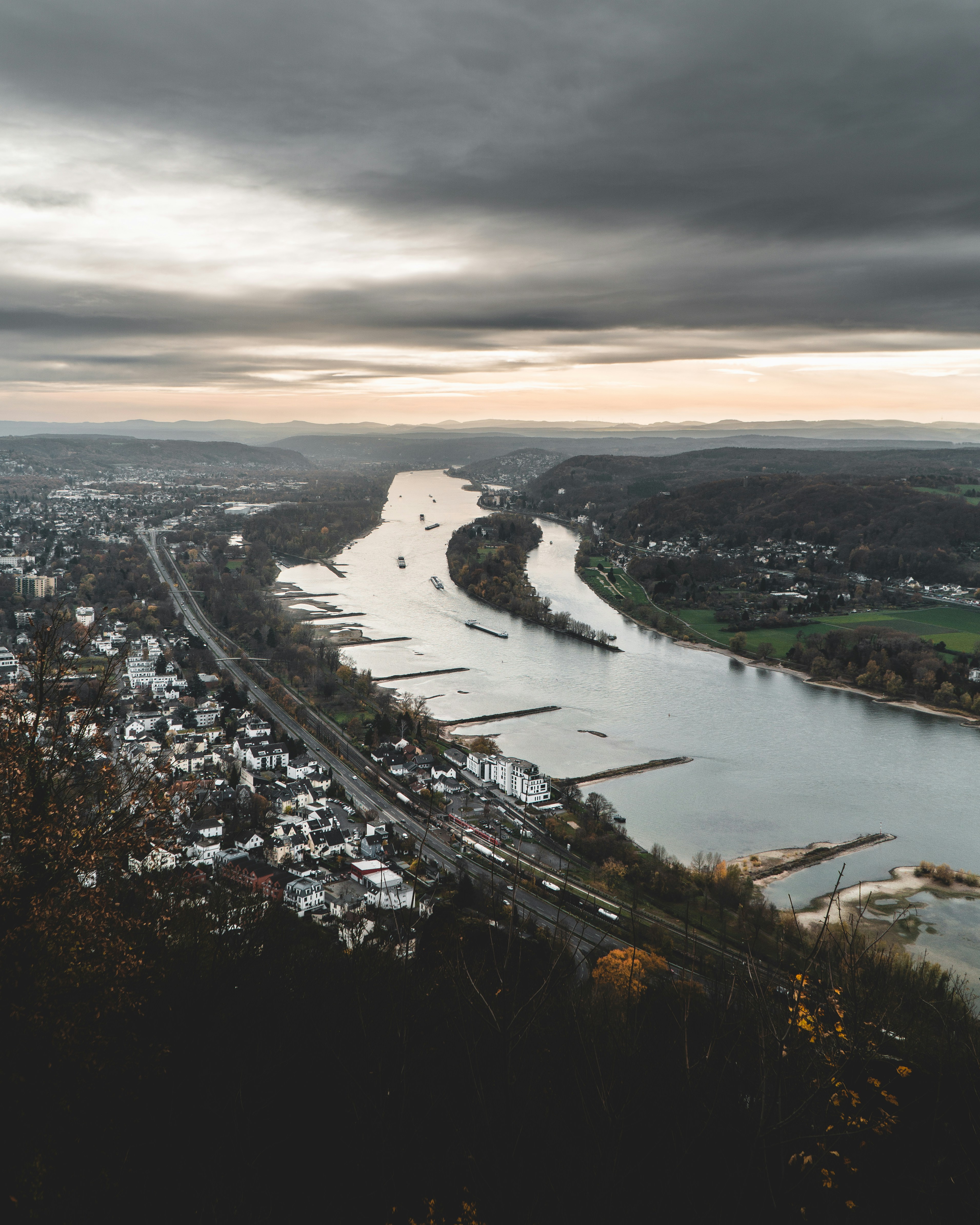 Aerial view of a winding river bordered by autumn foliage and a quaint town, showcasing the harmony between nature and urban life.