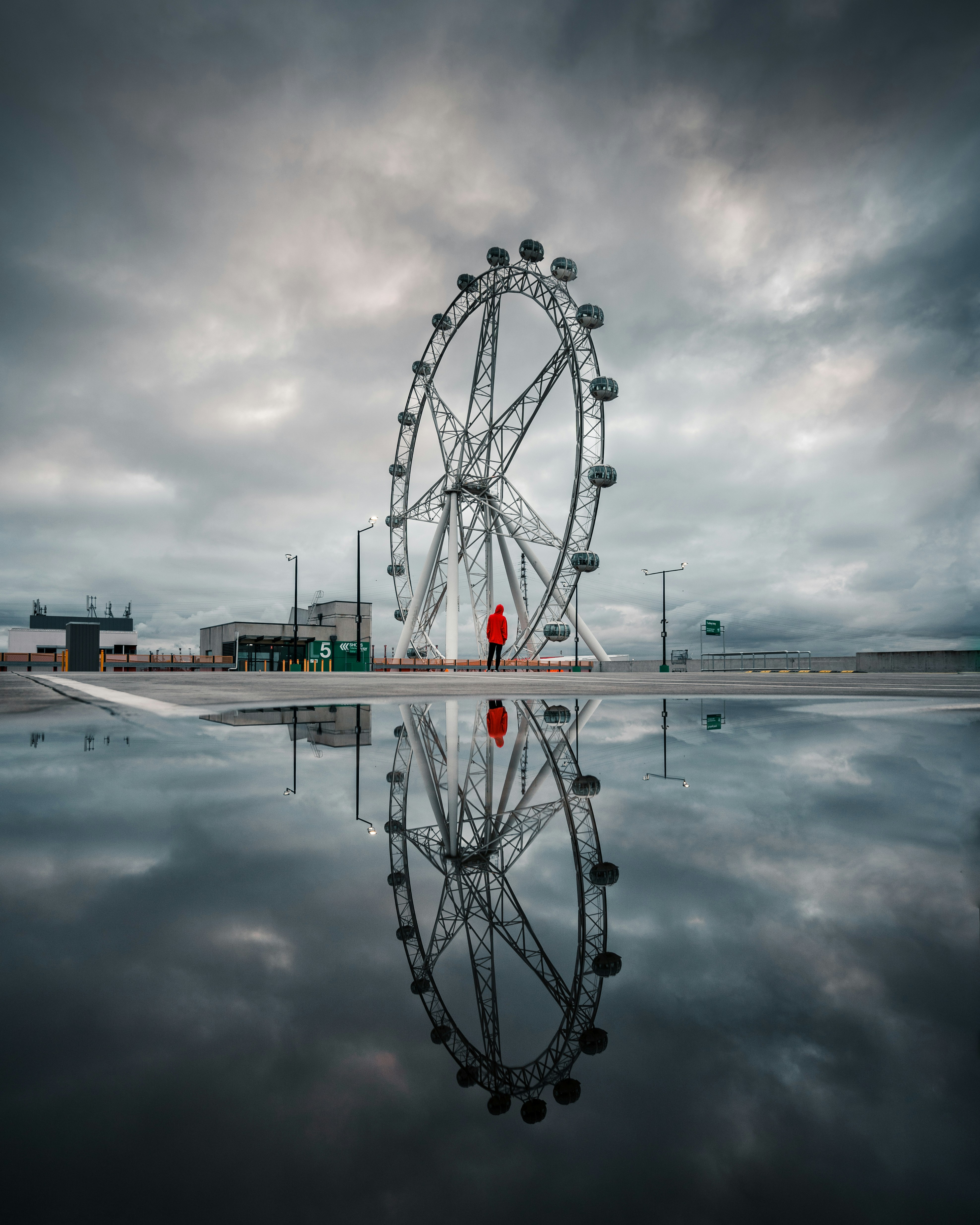 Grande roue près du plan d’eau sous un ciel nuageux pendant la journée ...