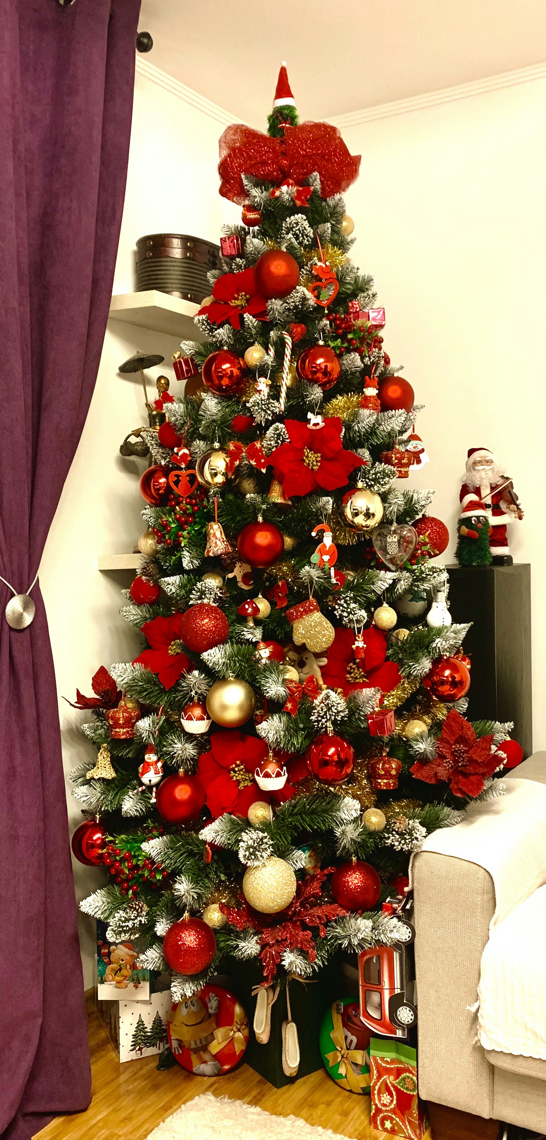 Crimson Crown: A Snow-Dusted Christmas Tree Glowing in Red and Gold
