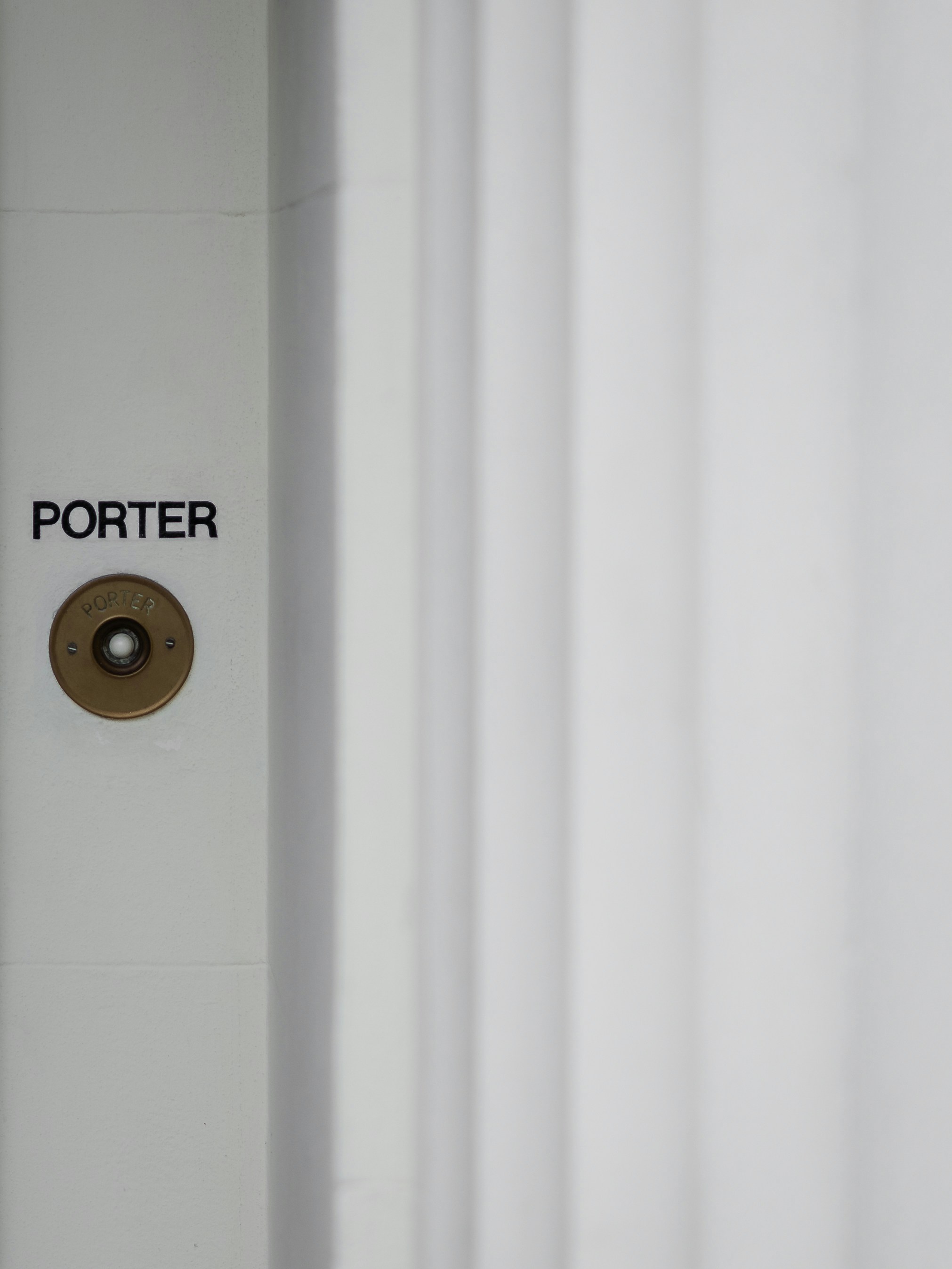 Threshold of Portals: Brass Peephole Framed by Pale Panels