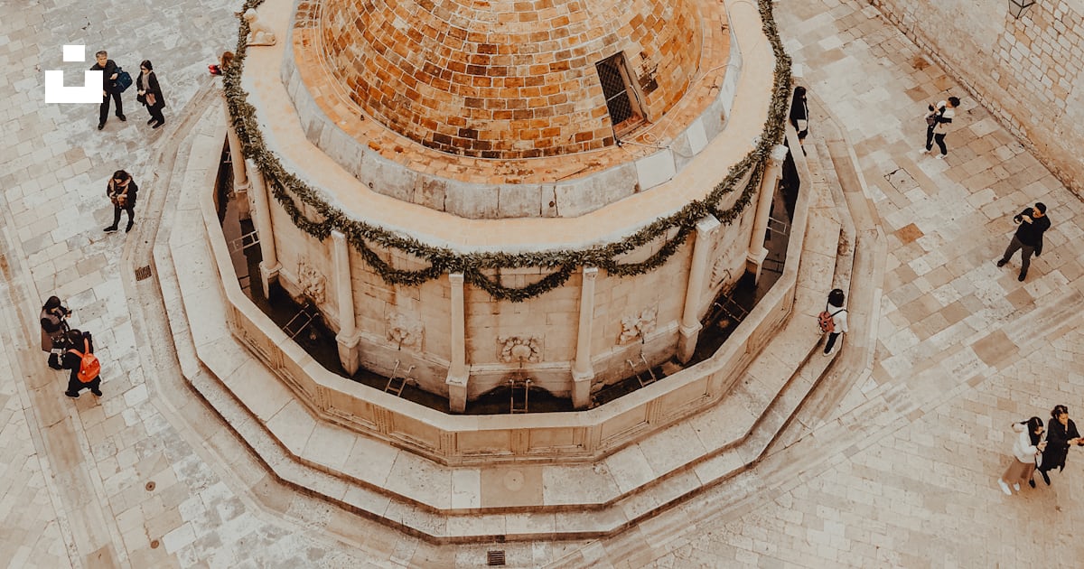 昼間、茶色のコンクリートの建物の近くの通りを歩く人々の写真 Unsplashの旅行の無料画像
