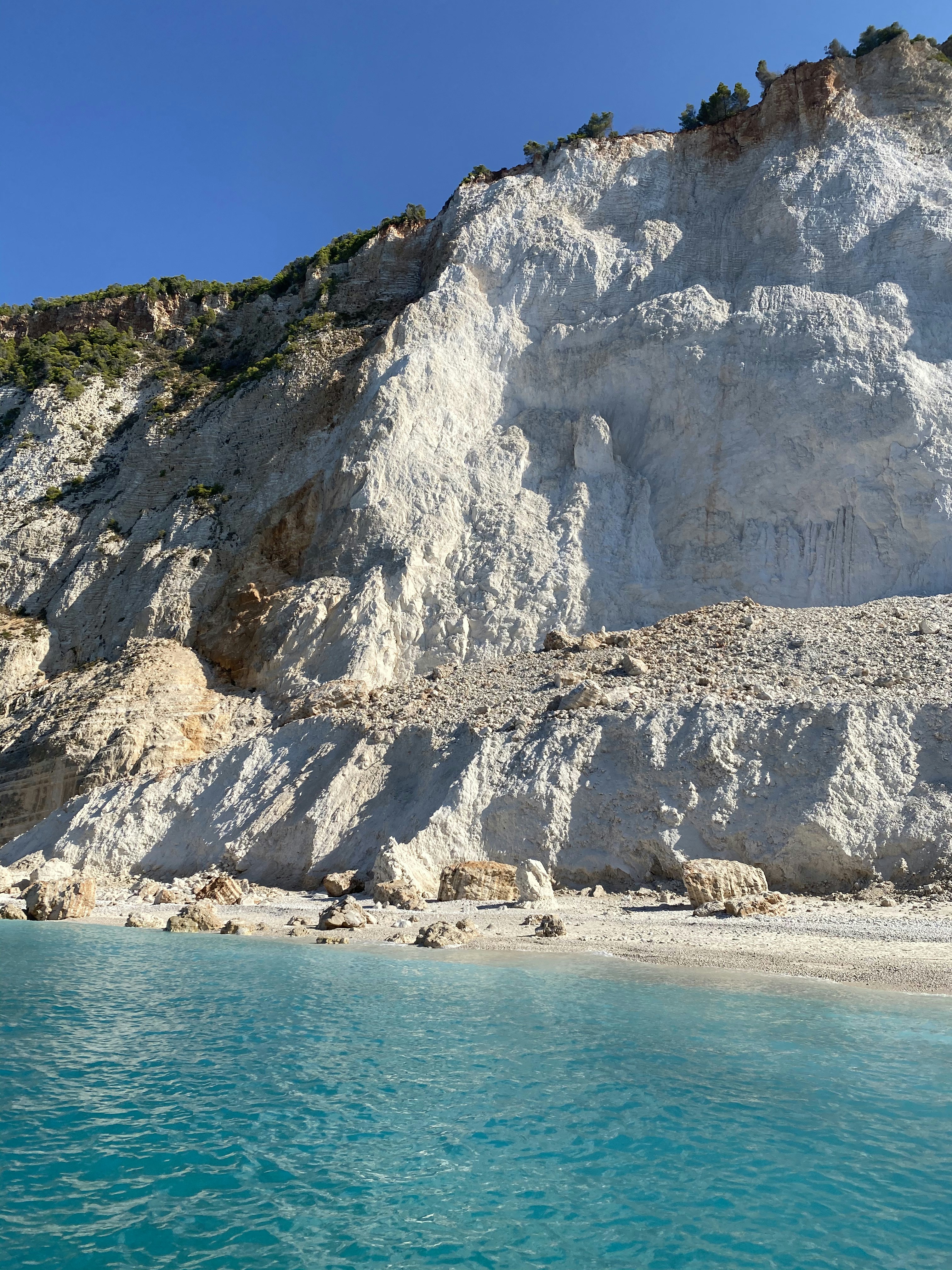 White and brown rock formation near body of water during daytime photo ...