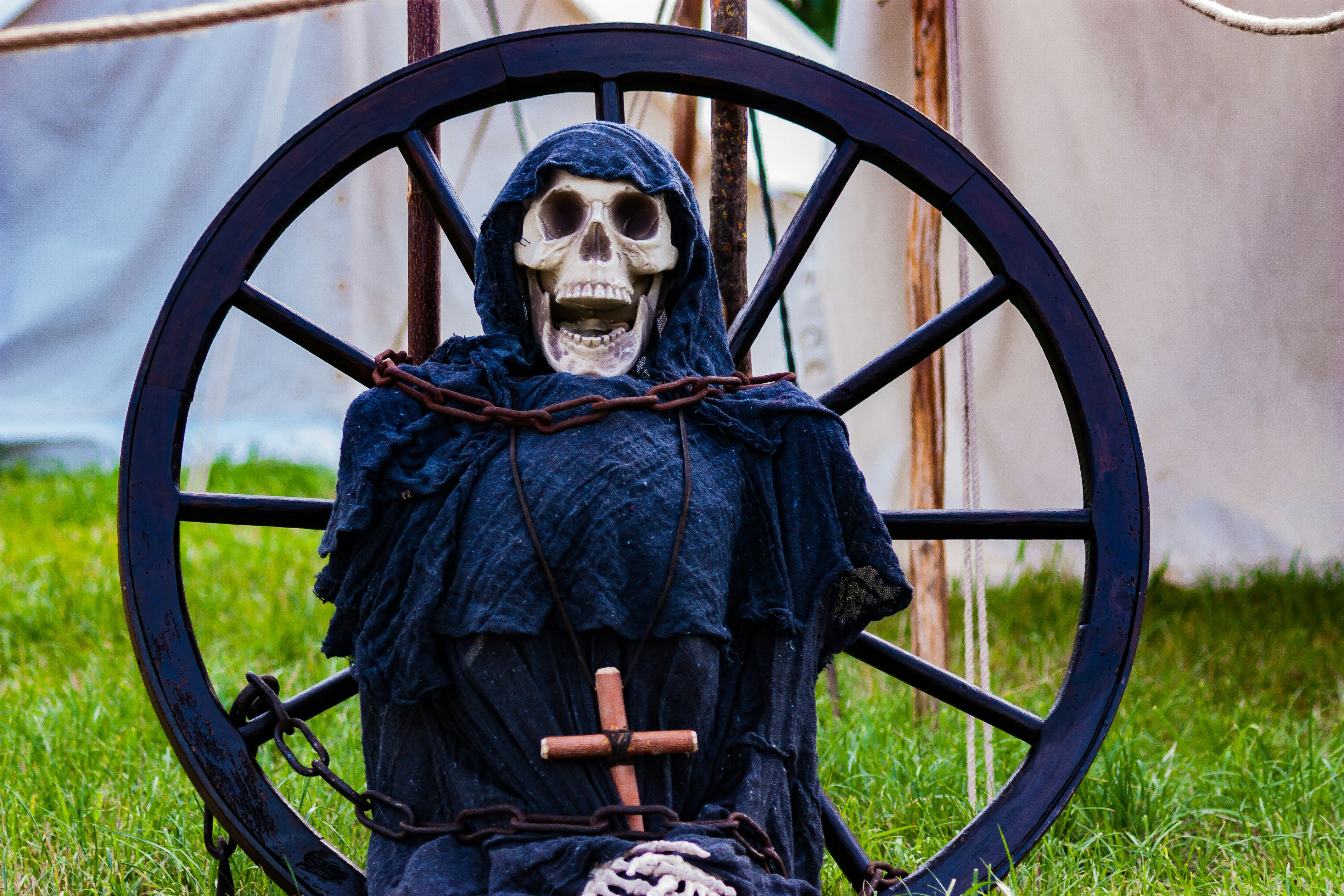 Skeleton wearing blue and black coat and white mask sitting on black ...