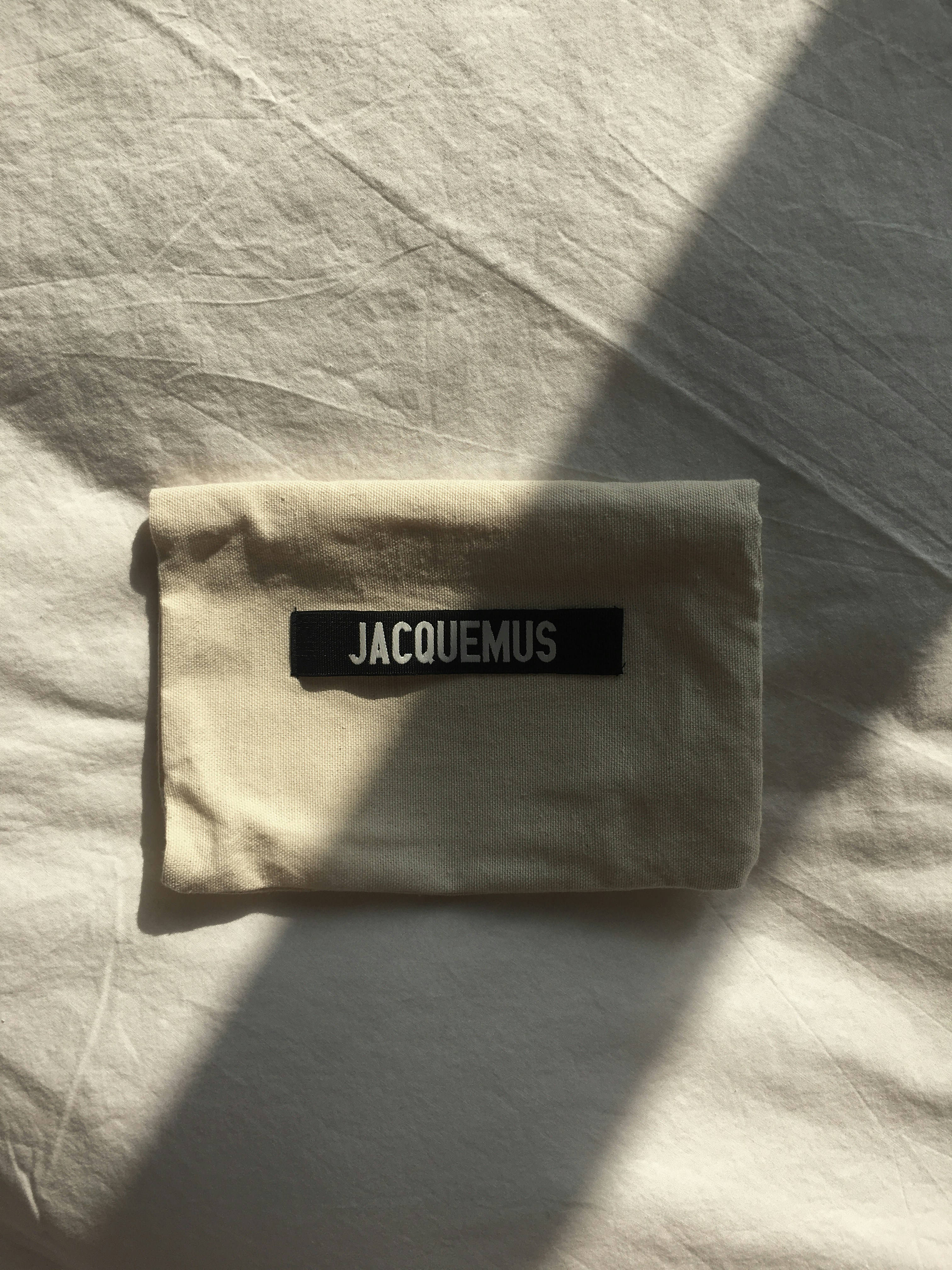 Diagonal Sunlight on a Jacquemus Pouch Resting on Crinkled Linen