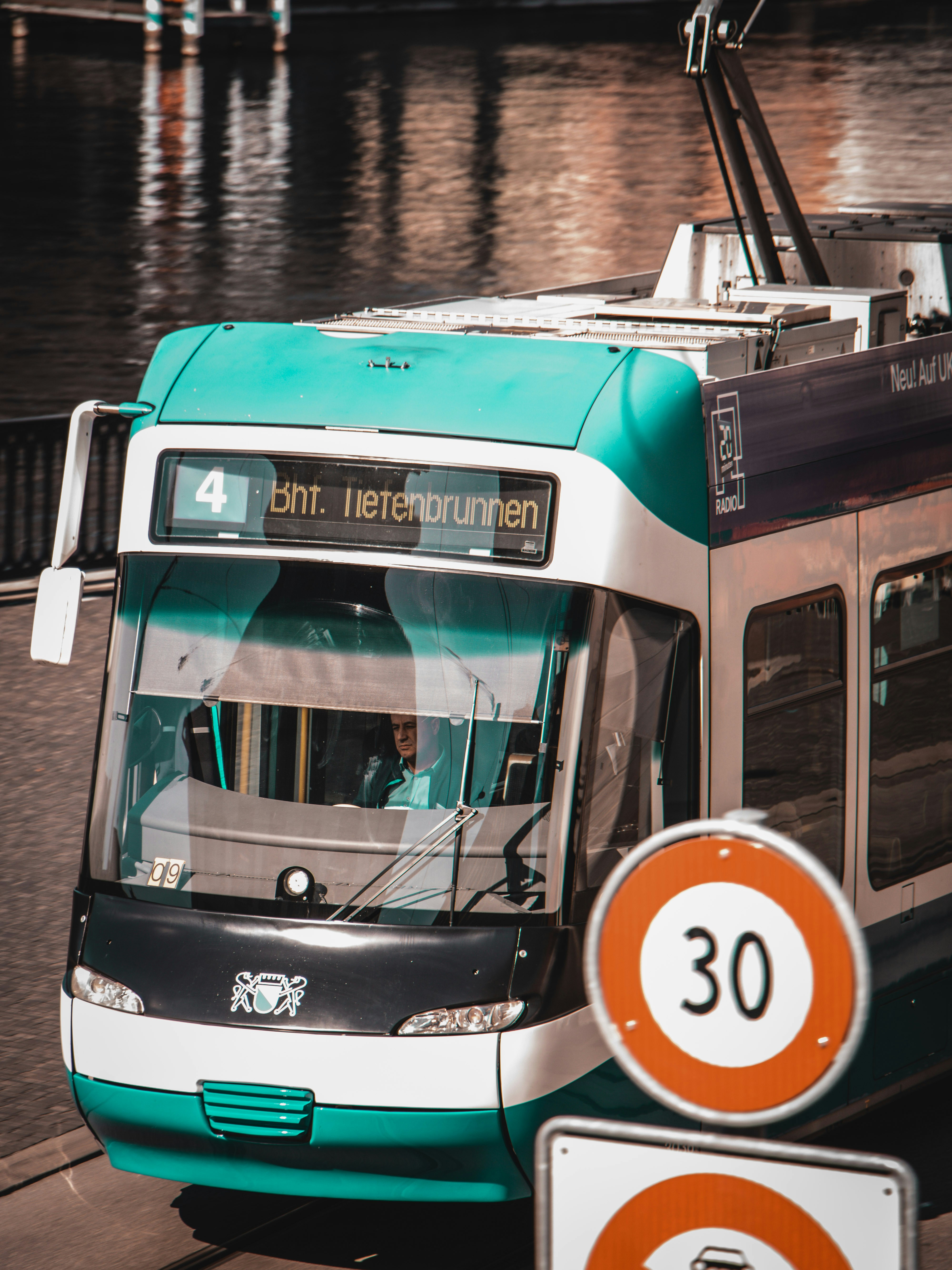 Turquoise tram glides through harbor dusk