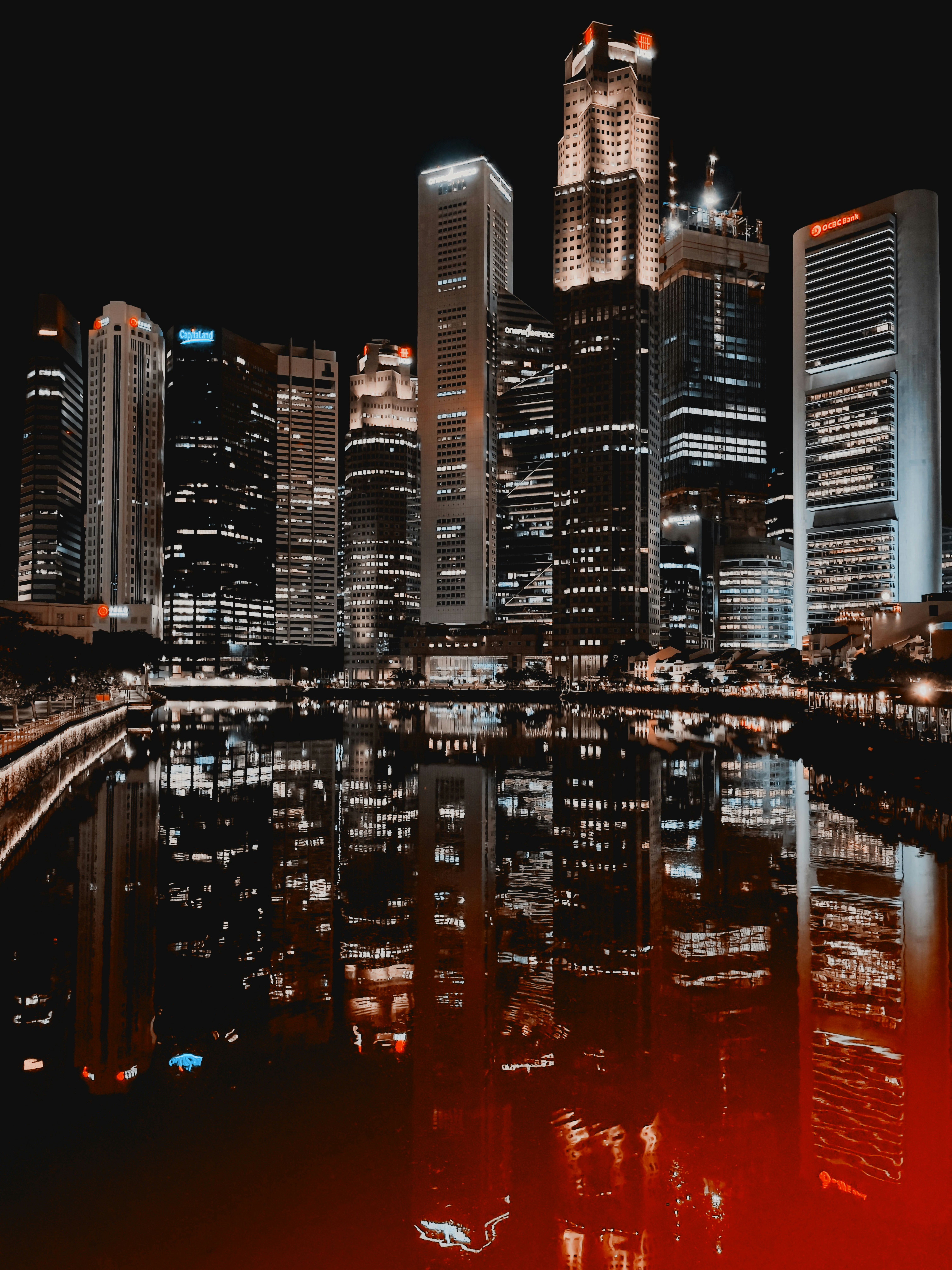 Red-Tinted Skyline Reflections Across a Night Canal