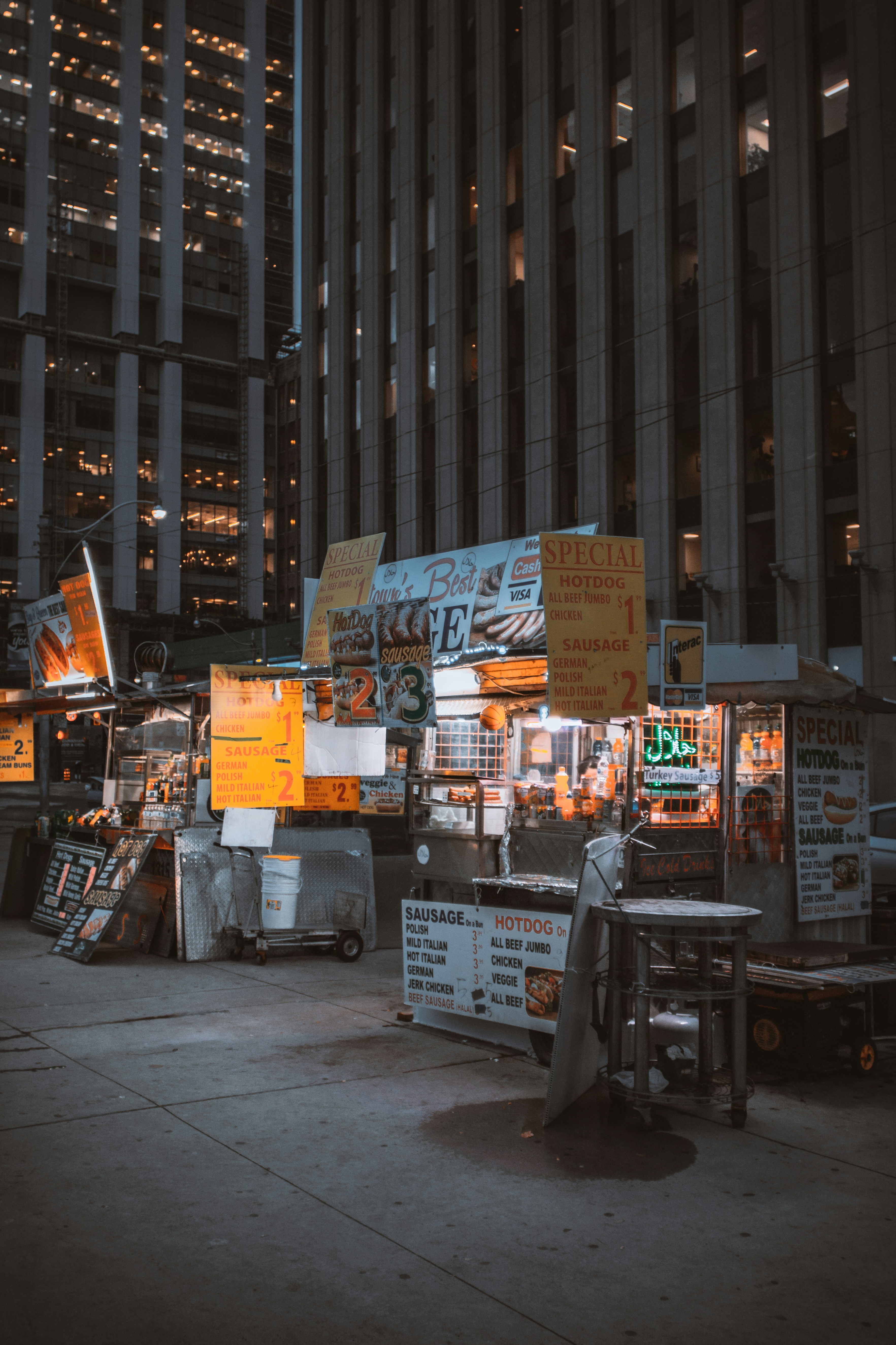 Vibrant food stalls illuminated at night, showcasing a variety of street food offerings in a bustling urban environment.