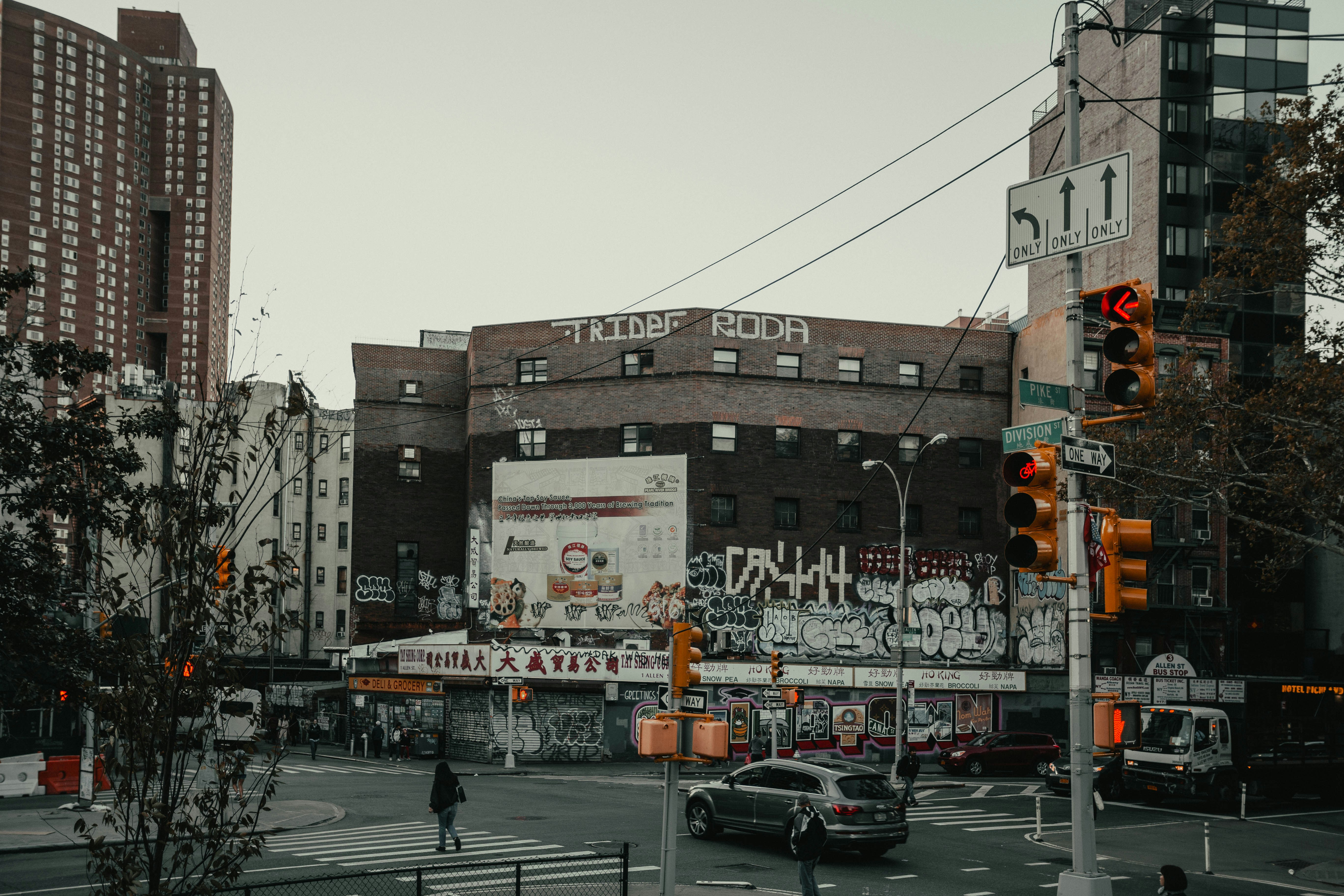Vibrant street art adorns a building in an urban setting, showcasing the intersection of culture and architecture. Traffic signals and pedestrians add to the dynamic city atmosphere.