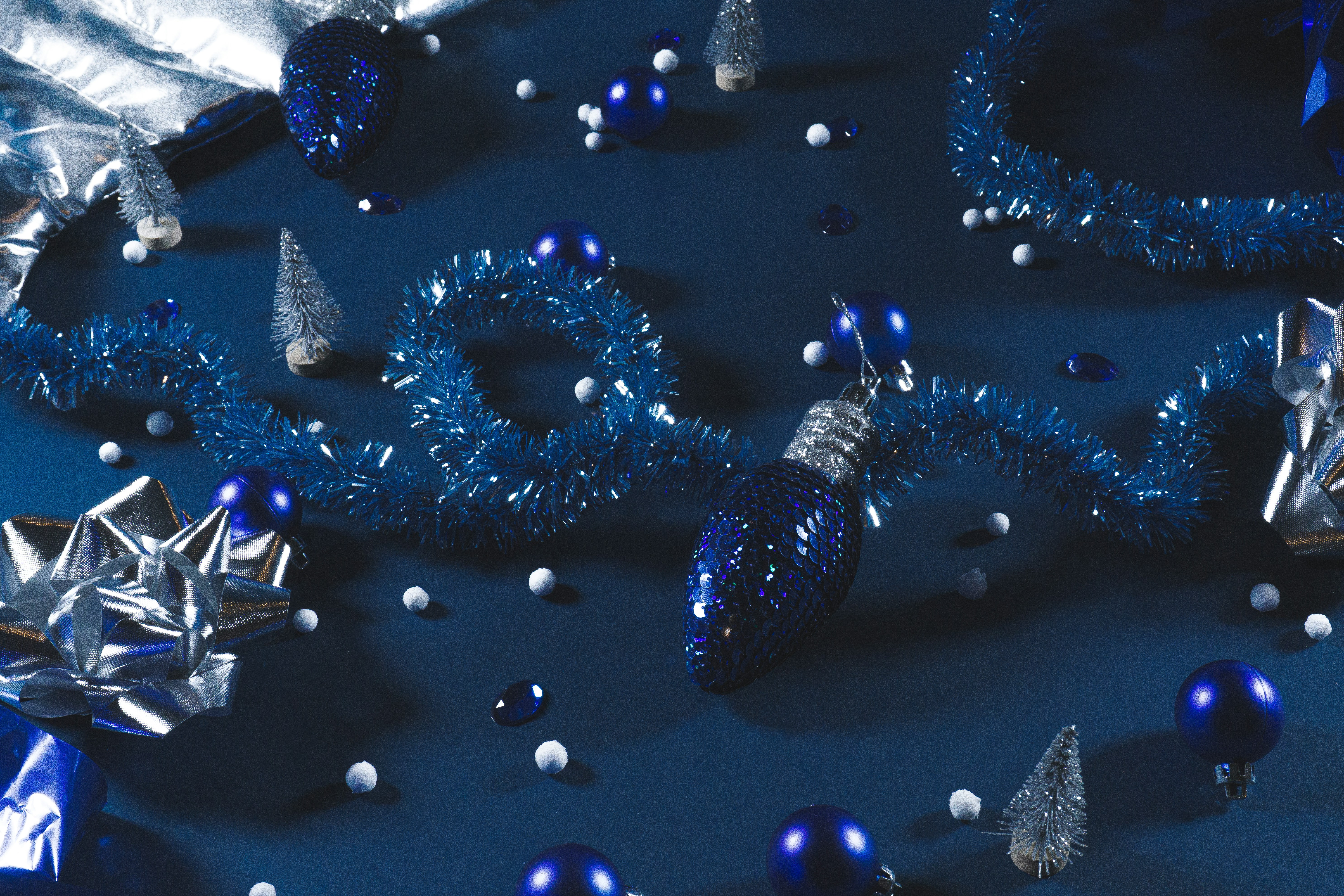 Blue Christmas background with Christmas trees, Christmas ornaments, and snow.