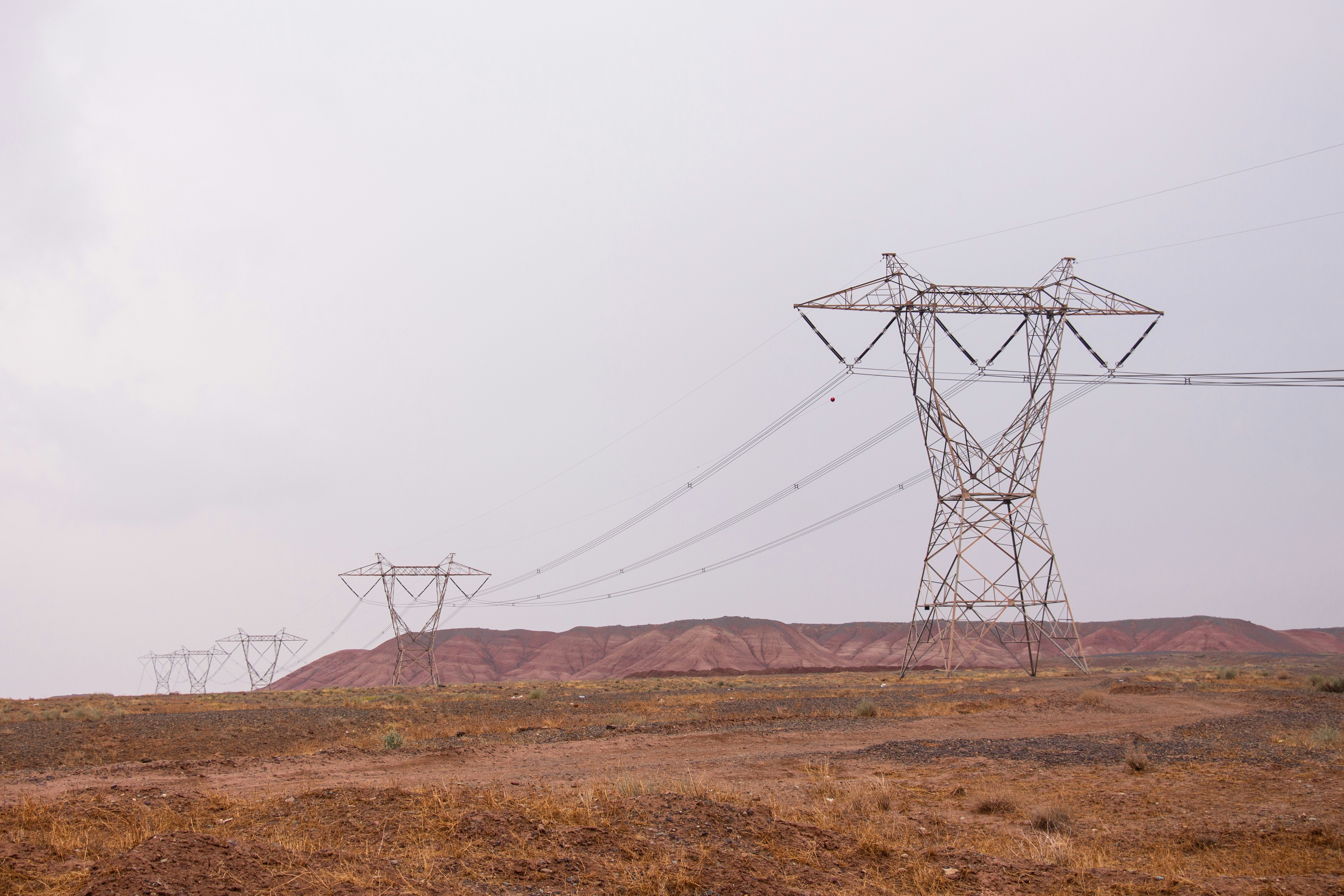 Black and white wind mill on brown field under white sky during daytime ...