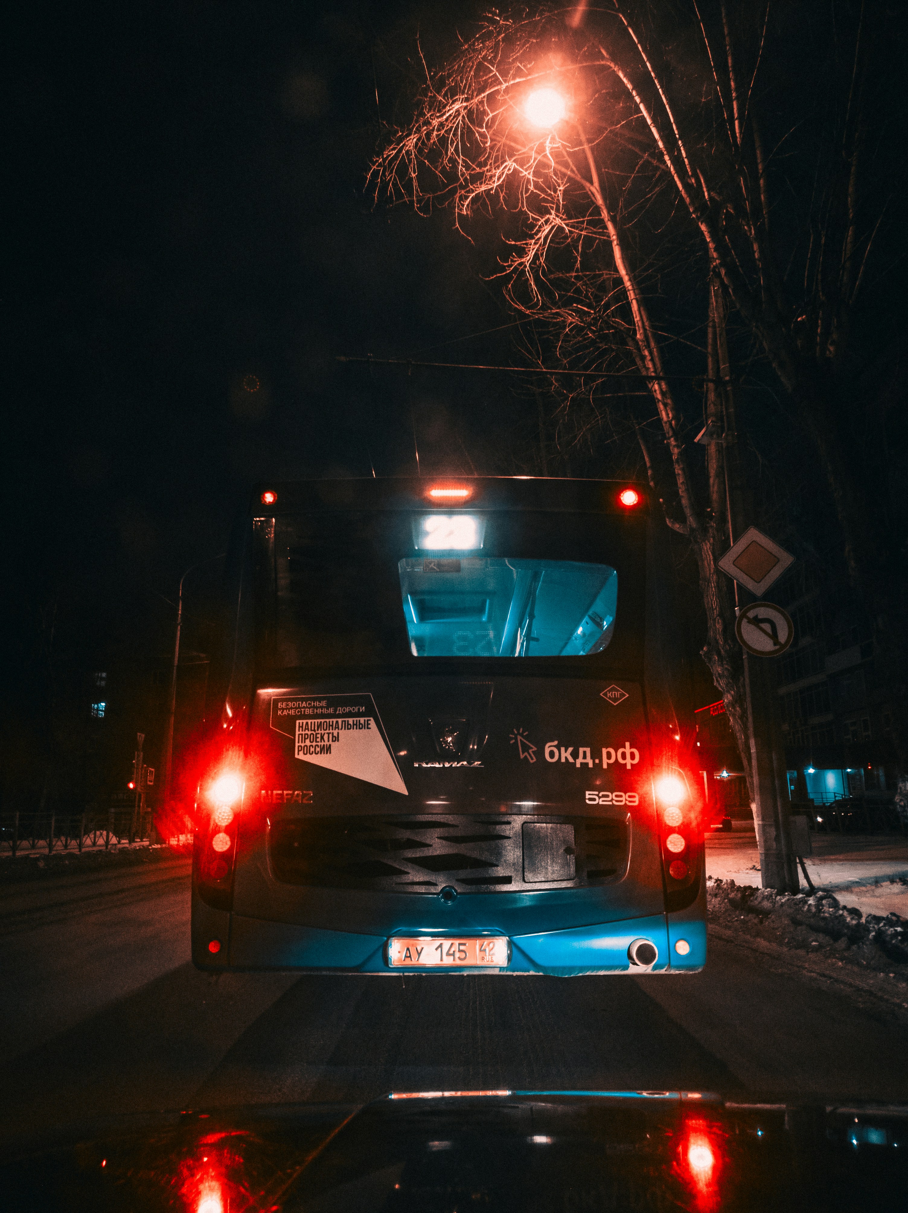Red Taillights and Cyan Cabin Glow on a Snow-Covered Street