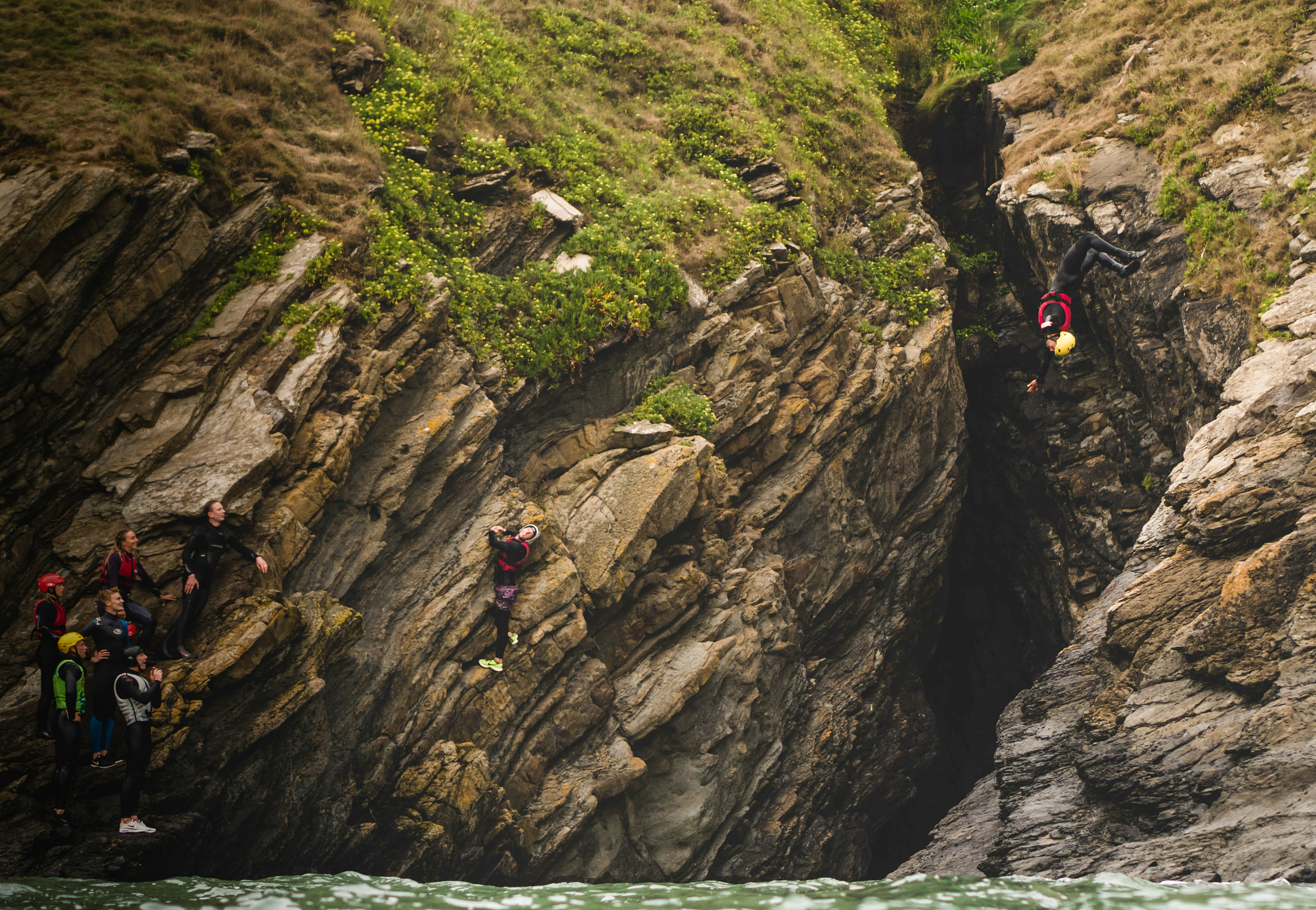 Coasteering Specialists exploring and showing off their skills at Baggy Point in North Devon. This jump in Croyde Bay is a great spectator spot as it always looks as if the Coasteerer will land on the rocks. 