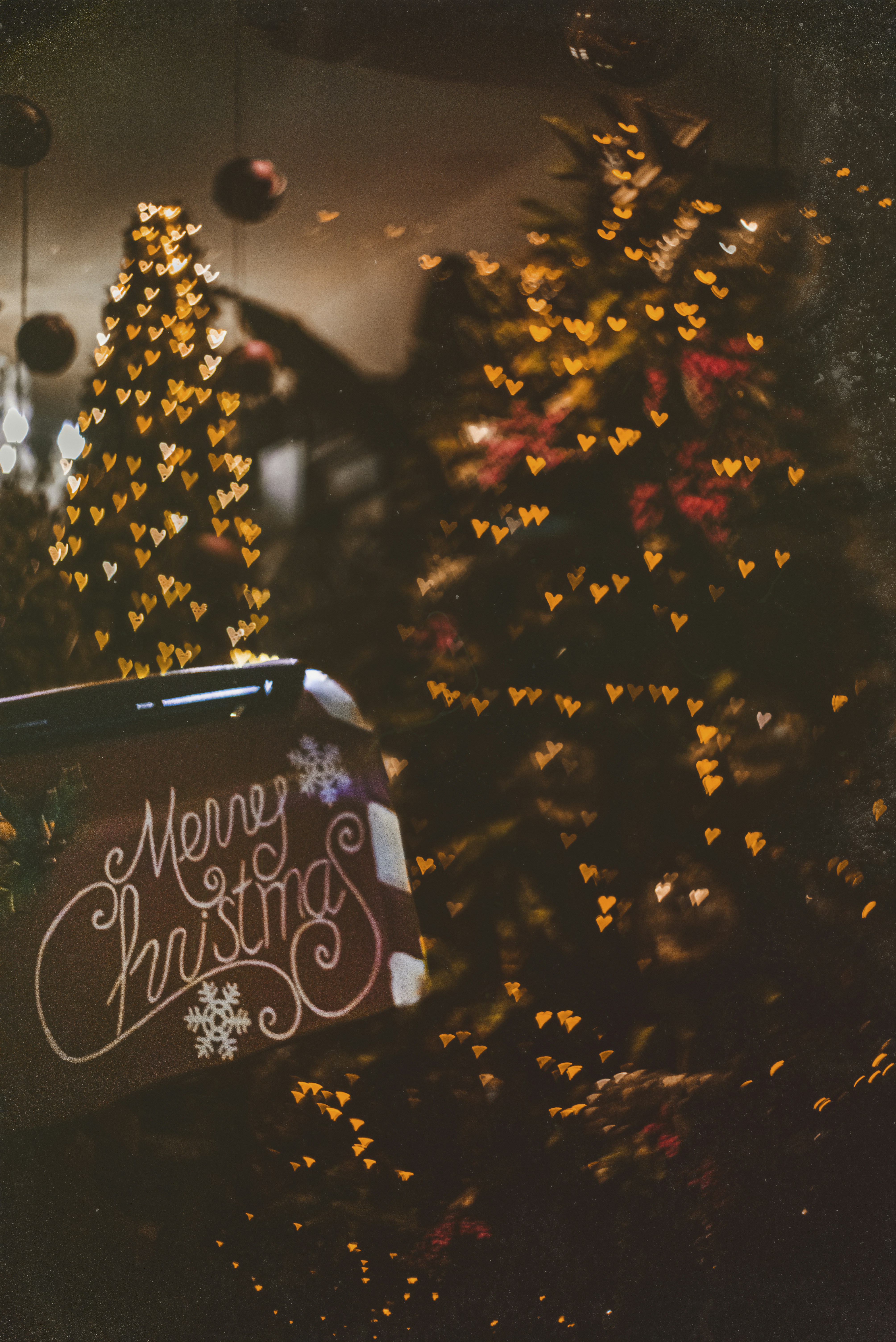 Heart-Bokeh Christmas: A Merry Card Framed by Warm Window Glow