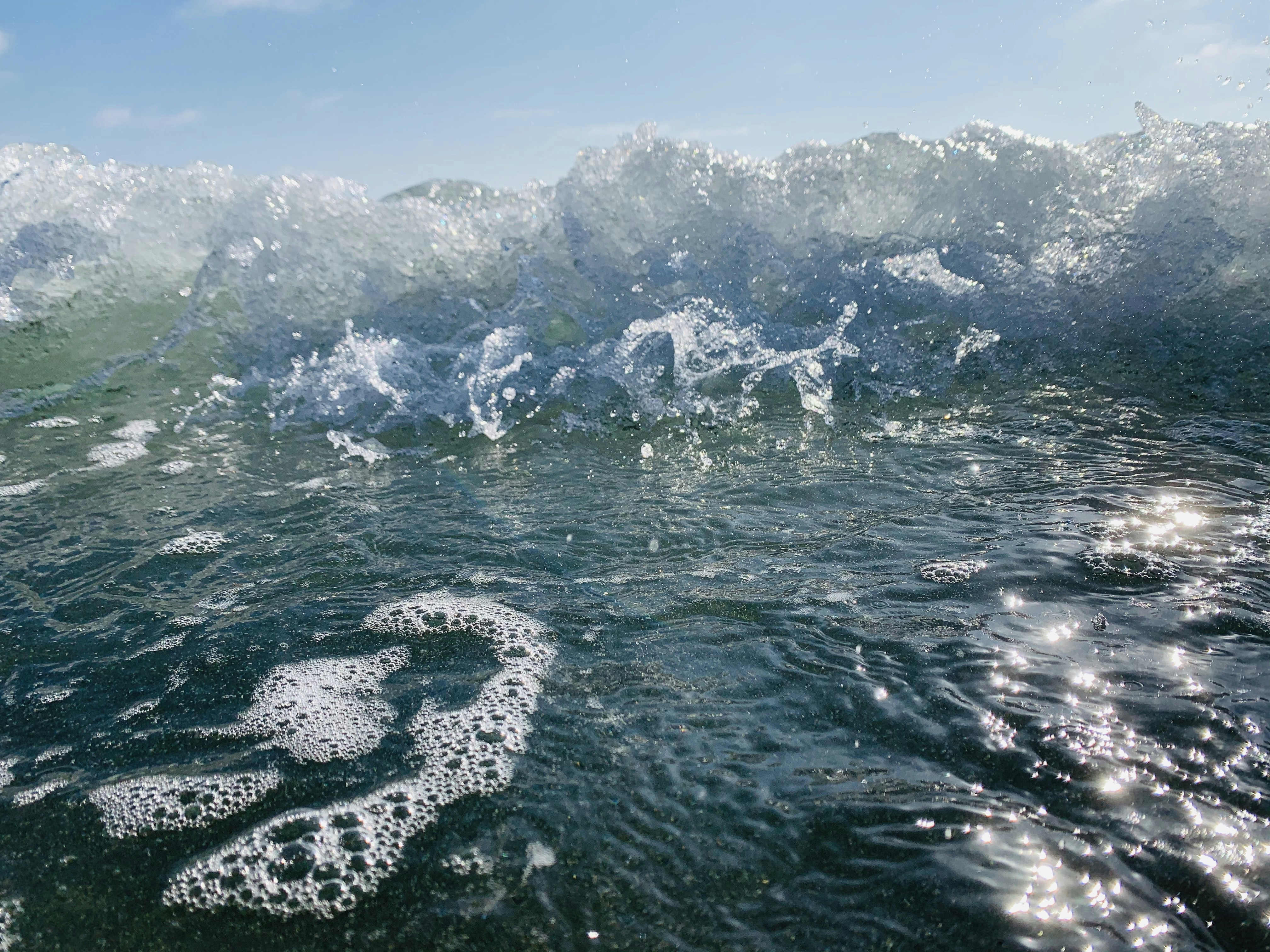 Lace of Light: A Close-Up on a Sunlit Ocean Breaker