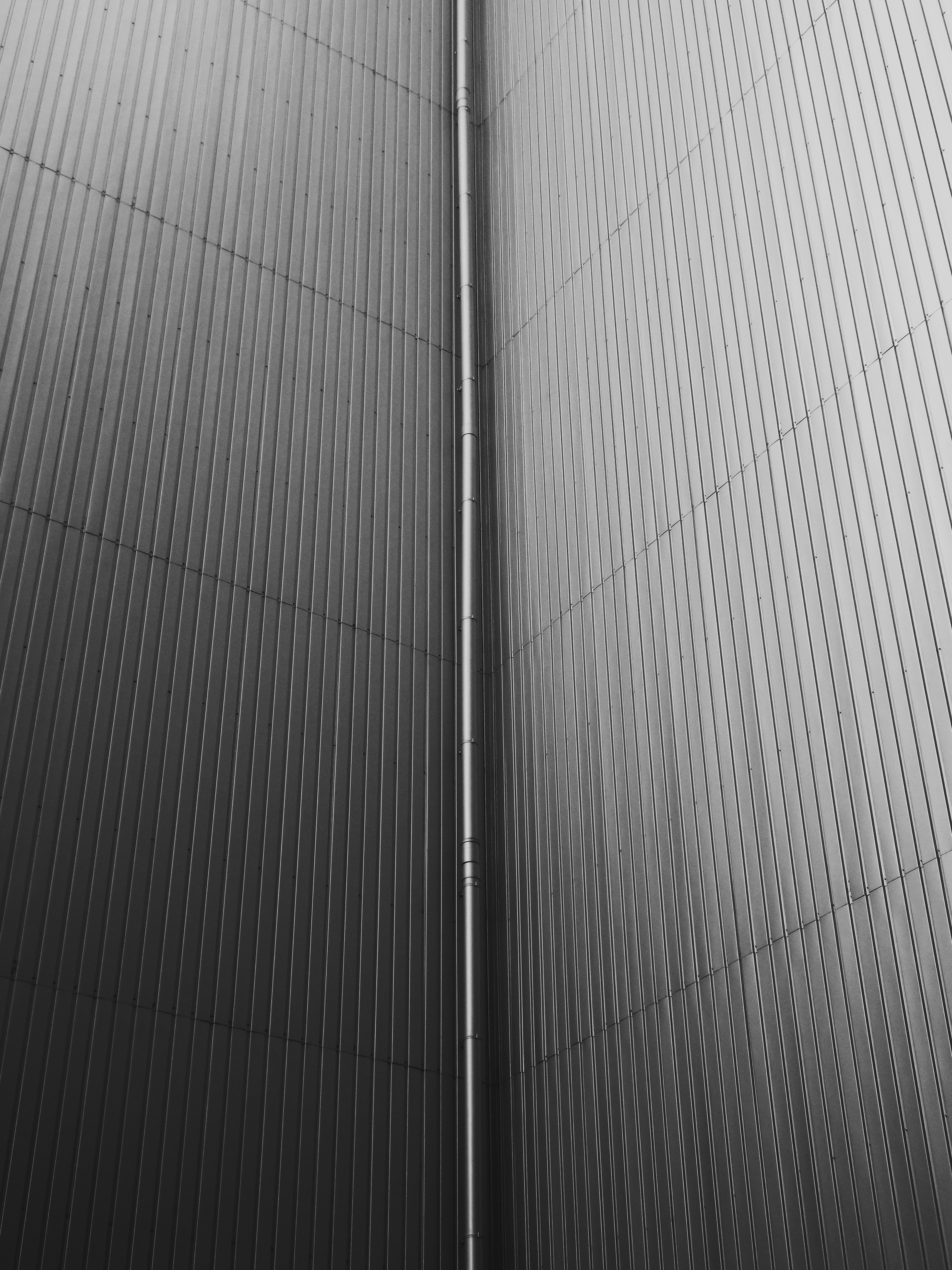 Abstract composition of vertical metal panels converging towards a single line, showcasing industrial design elements.