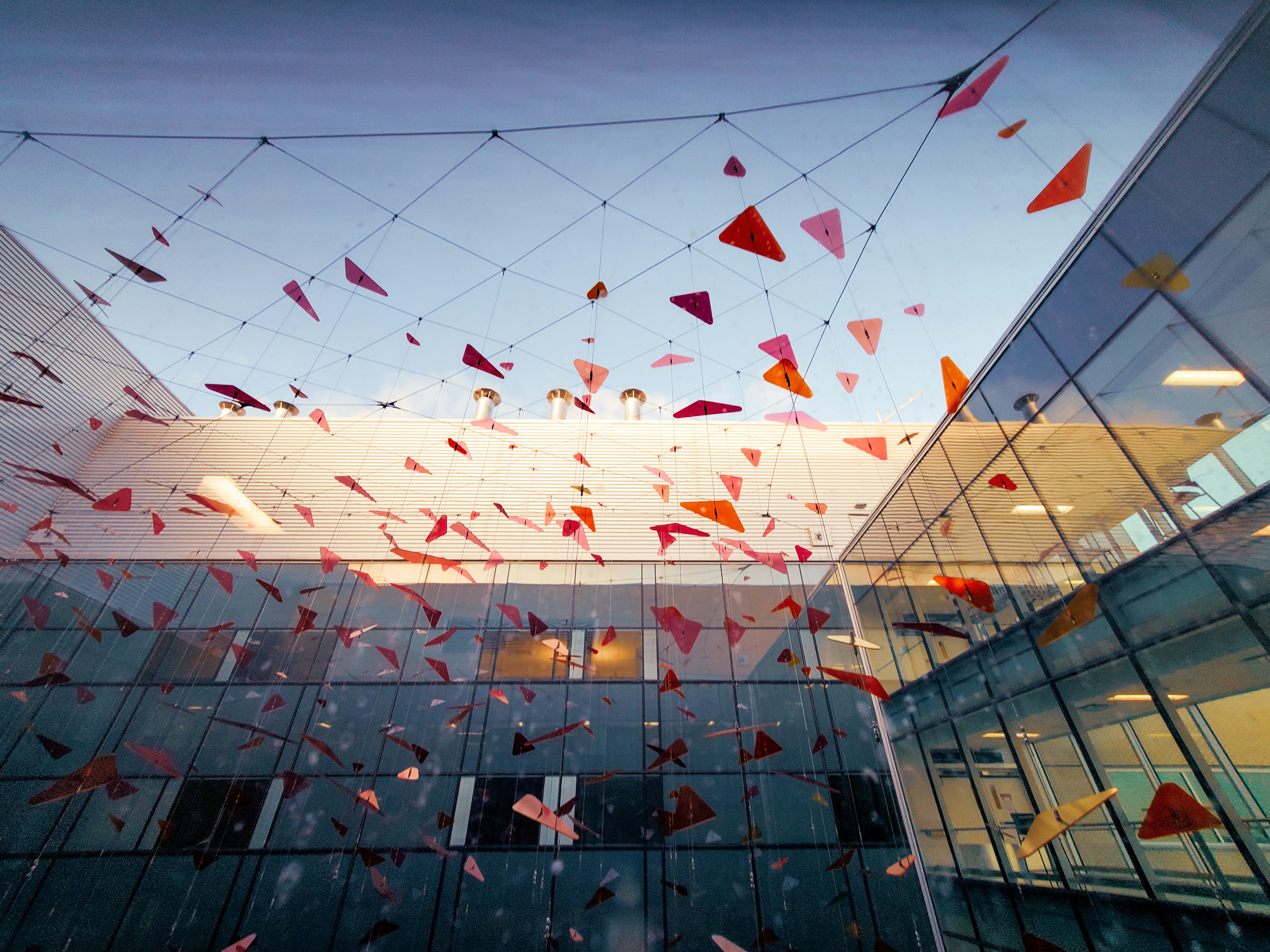 Crimson Triangles Draped Across a Glass Atrium Ceiling