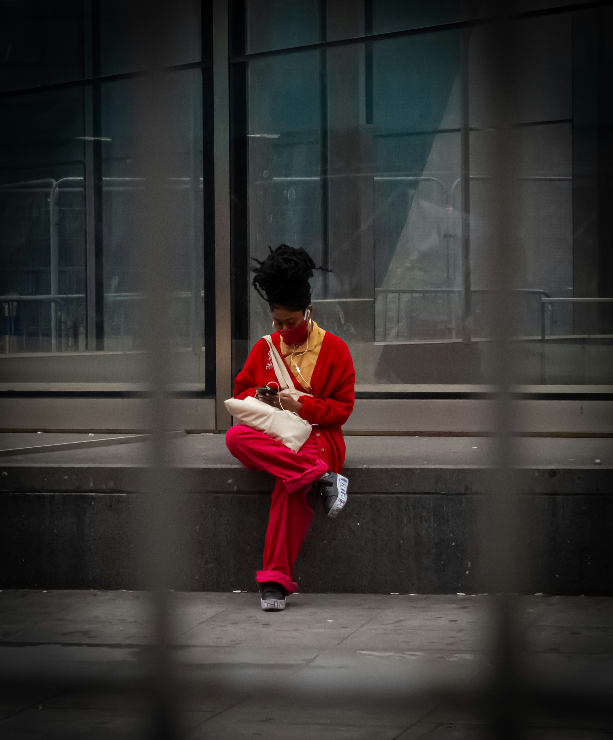 Man in red and white jacket sitting on gray concrete stairs photo ...