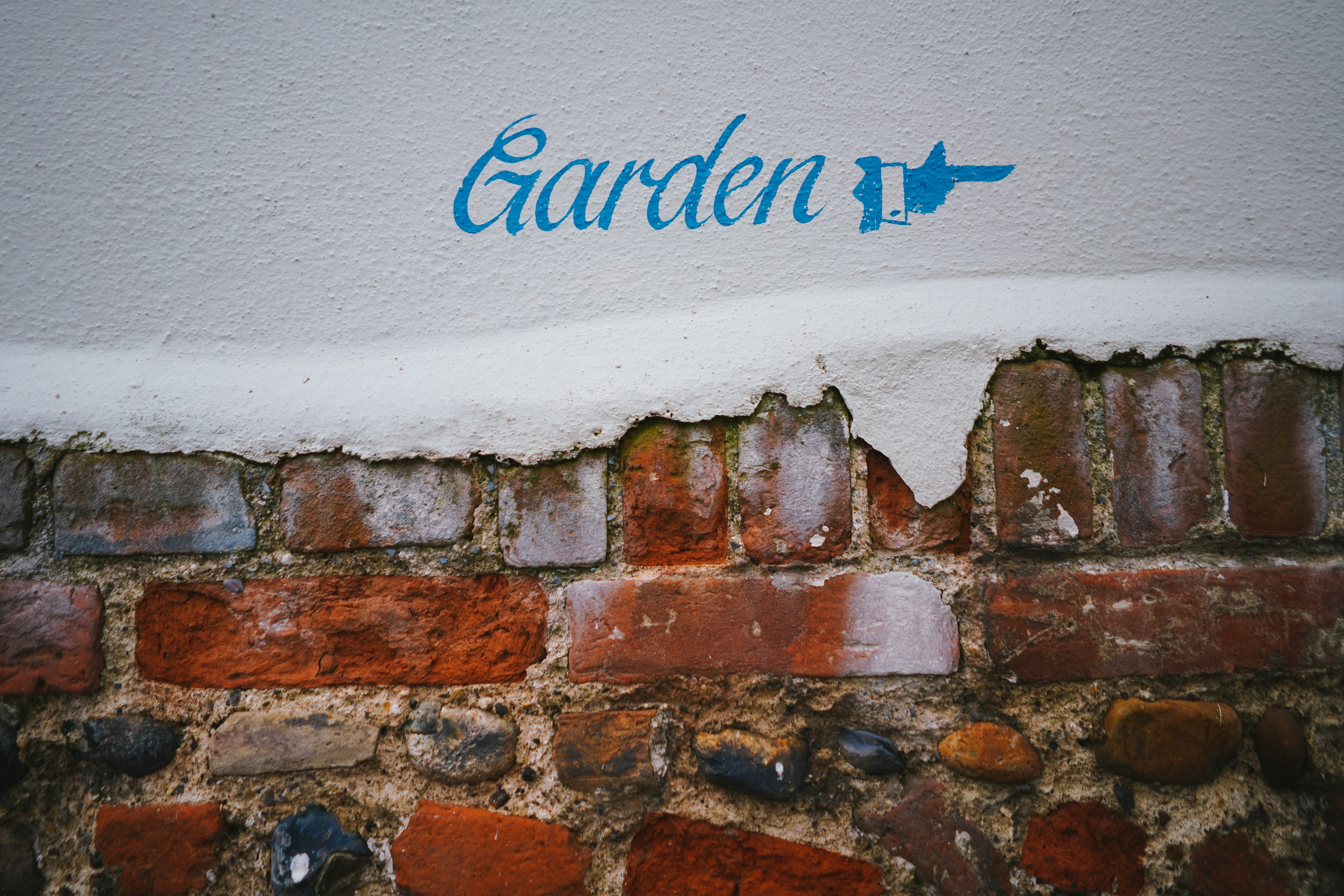 Blue Garden Script over a Weathered Brick Facade