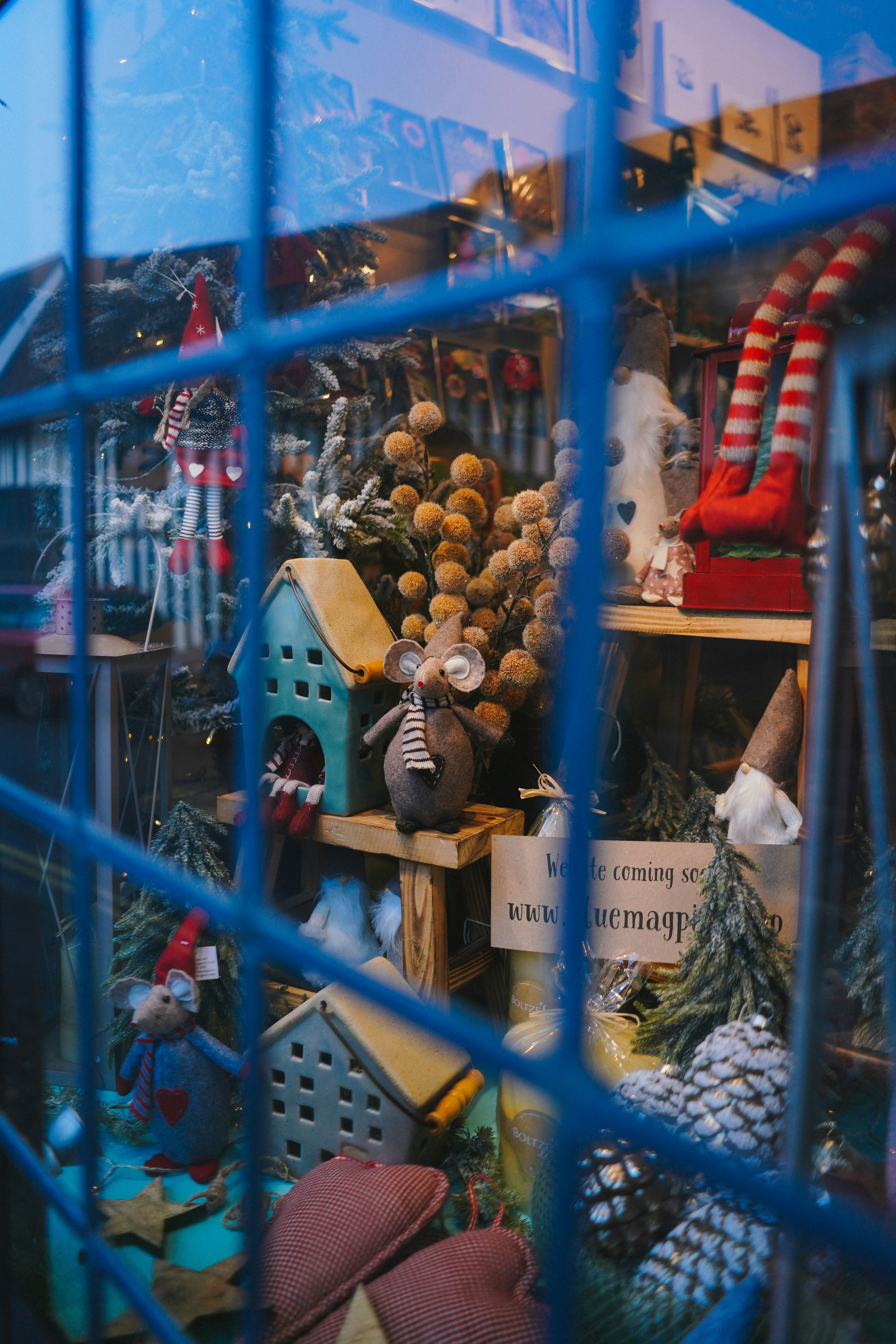 Shop Window Wonder: Cozy Holiday Figurines Framed by Blue Grids