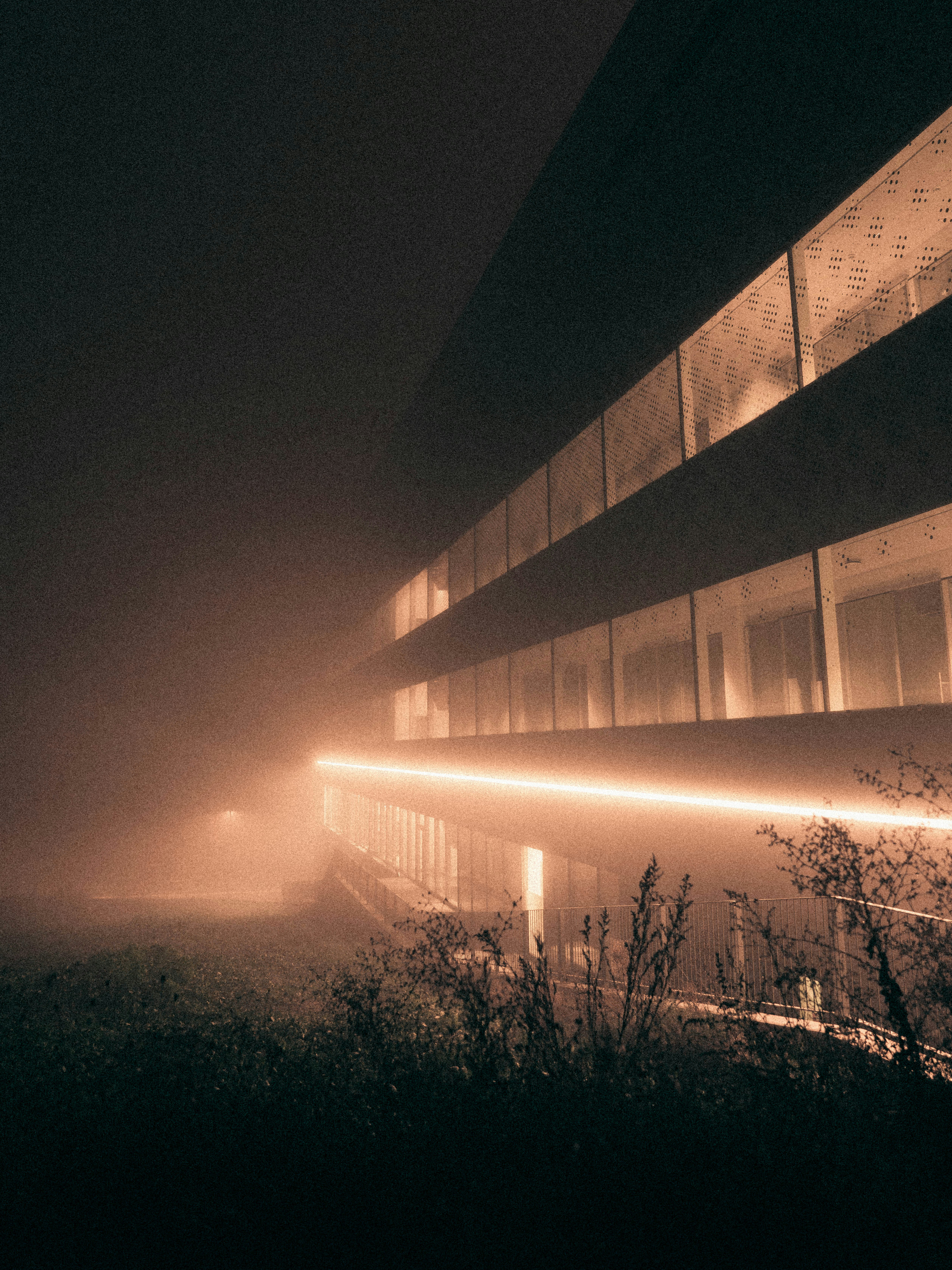 Neon Thread Through a Fog-Blanketed Modernist Facade