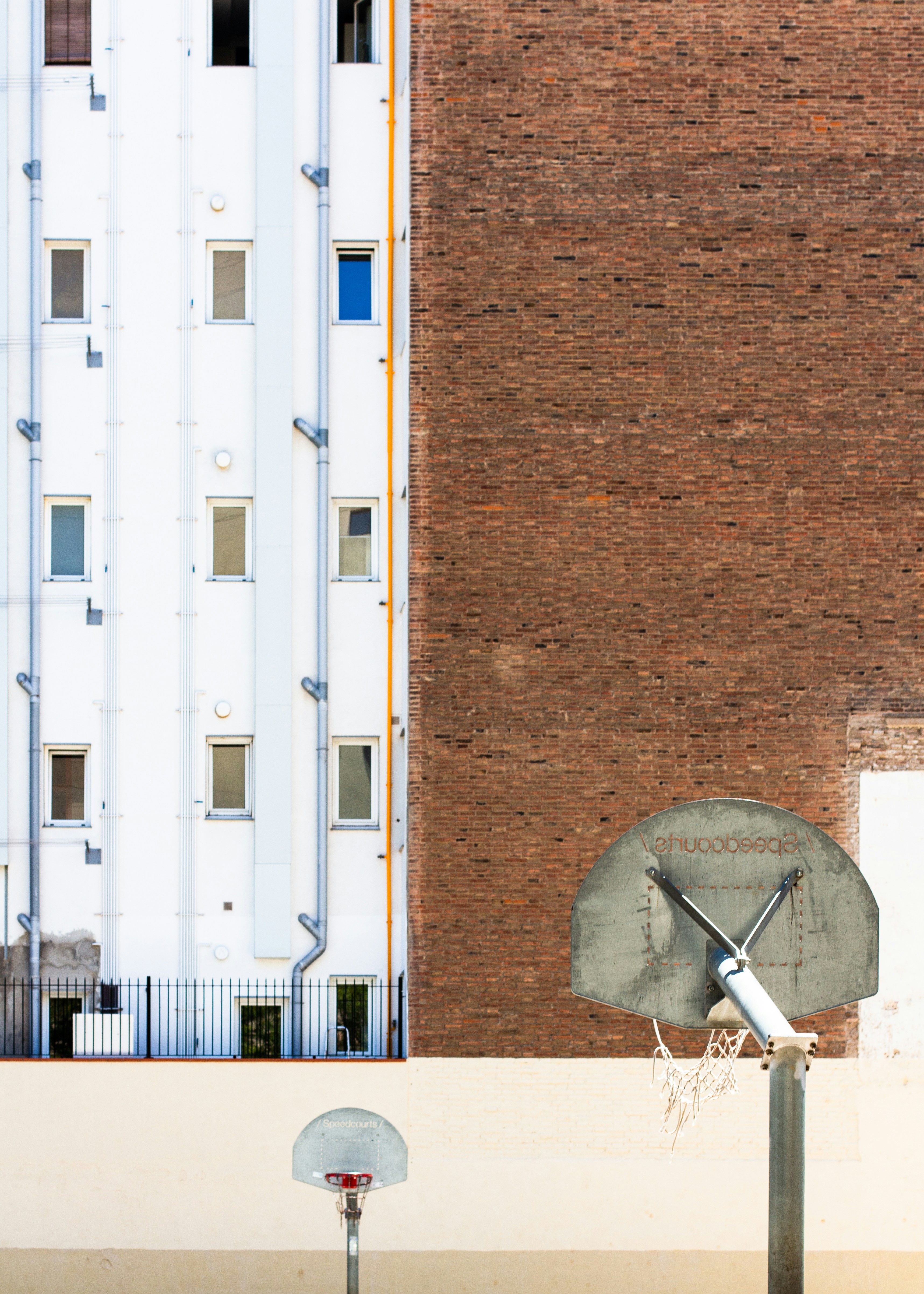 Rims and Facades: Urban Contrast Between Brick Wall and White Towers