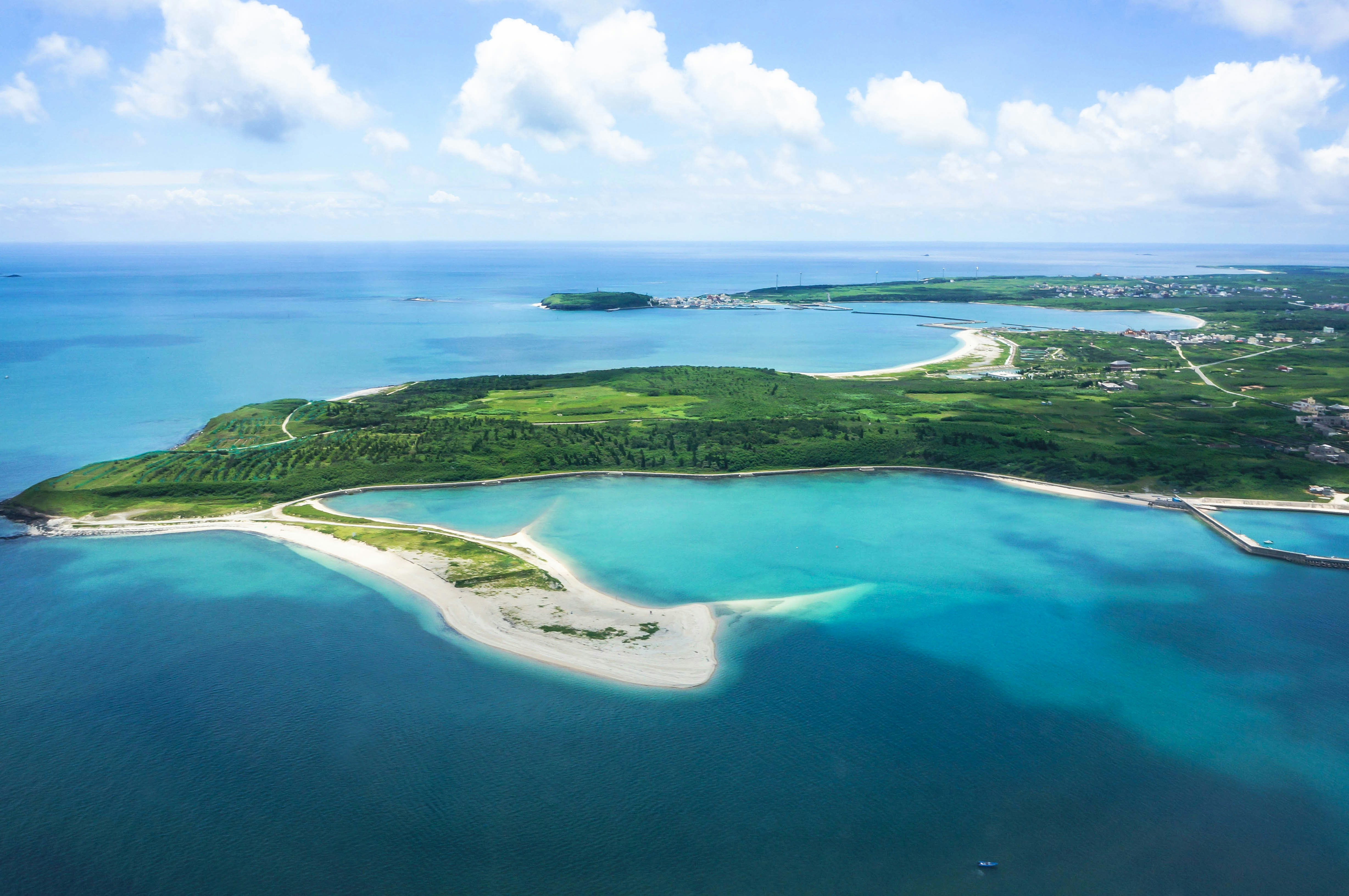 Aerial view of a lush coastal landscape with sandy beaches and turquoise waters, showcasing the harmony between land and sea.