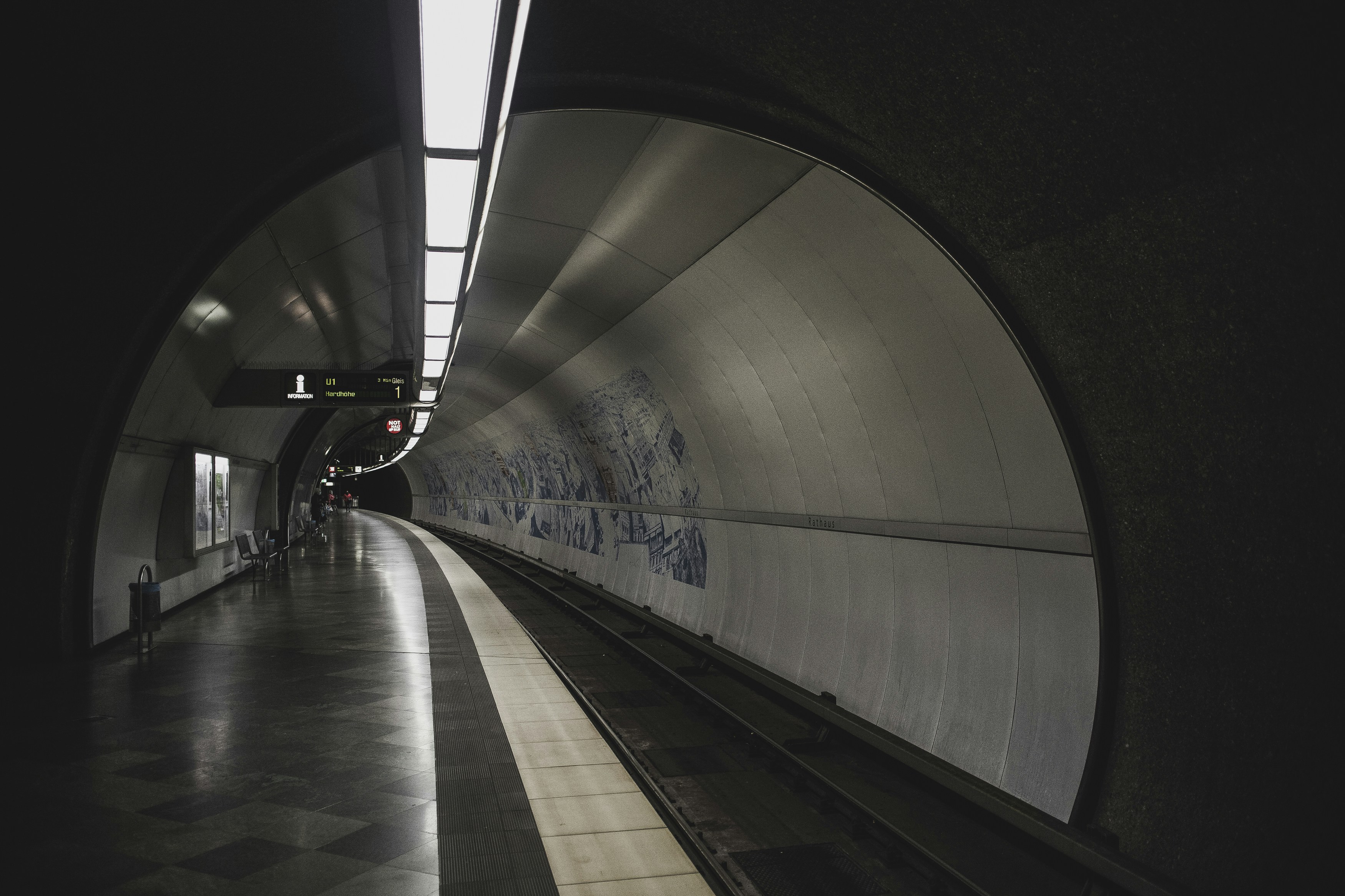 Dimly lit subway tunnel with a train emerging from the darkness.