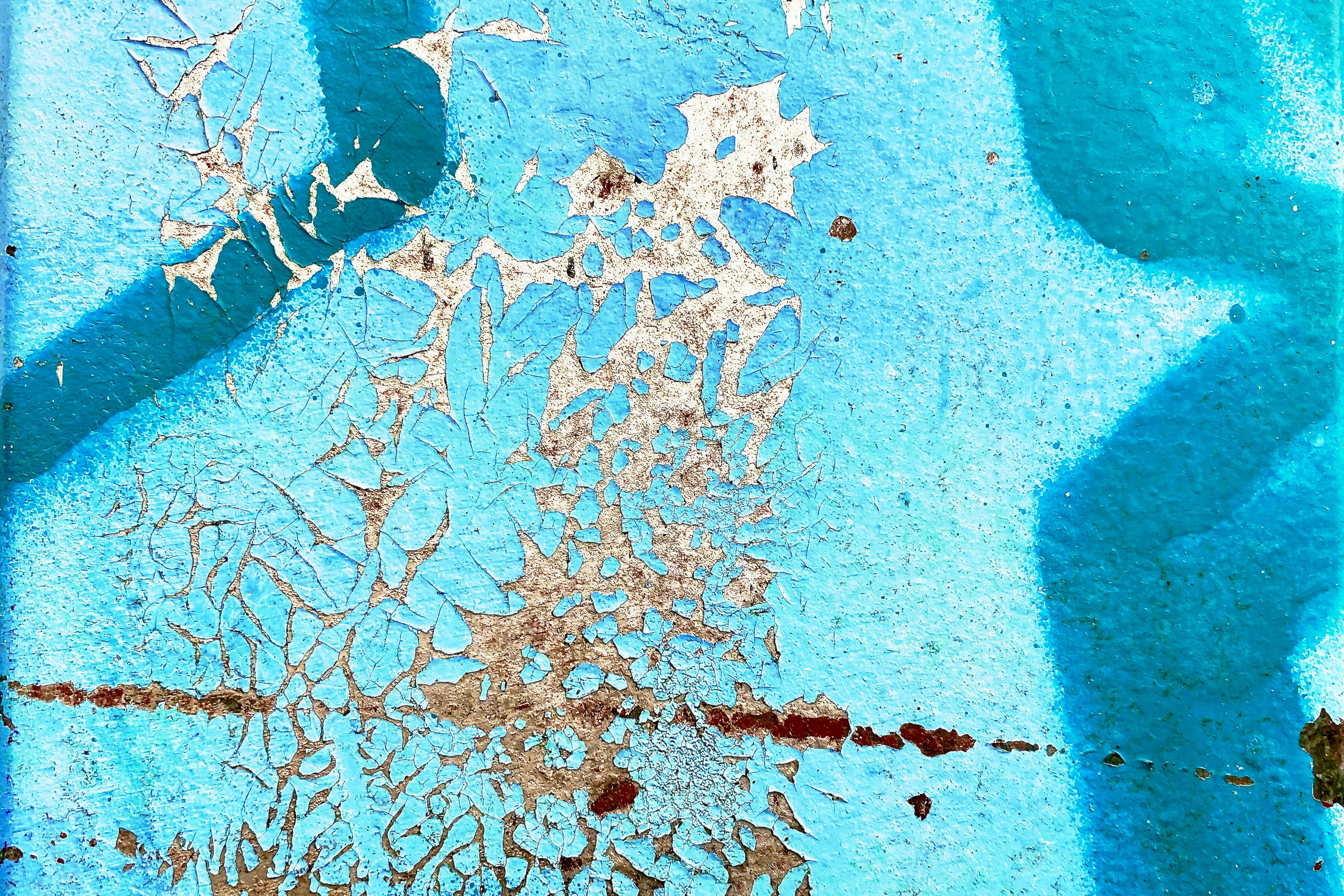 Beige Palimpsest on a Cyan Facade: Weathered Paint on a Sunlit Wall