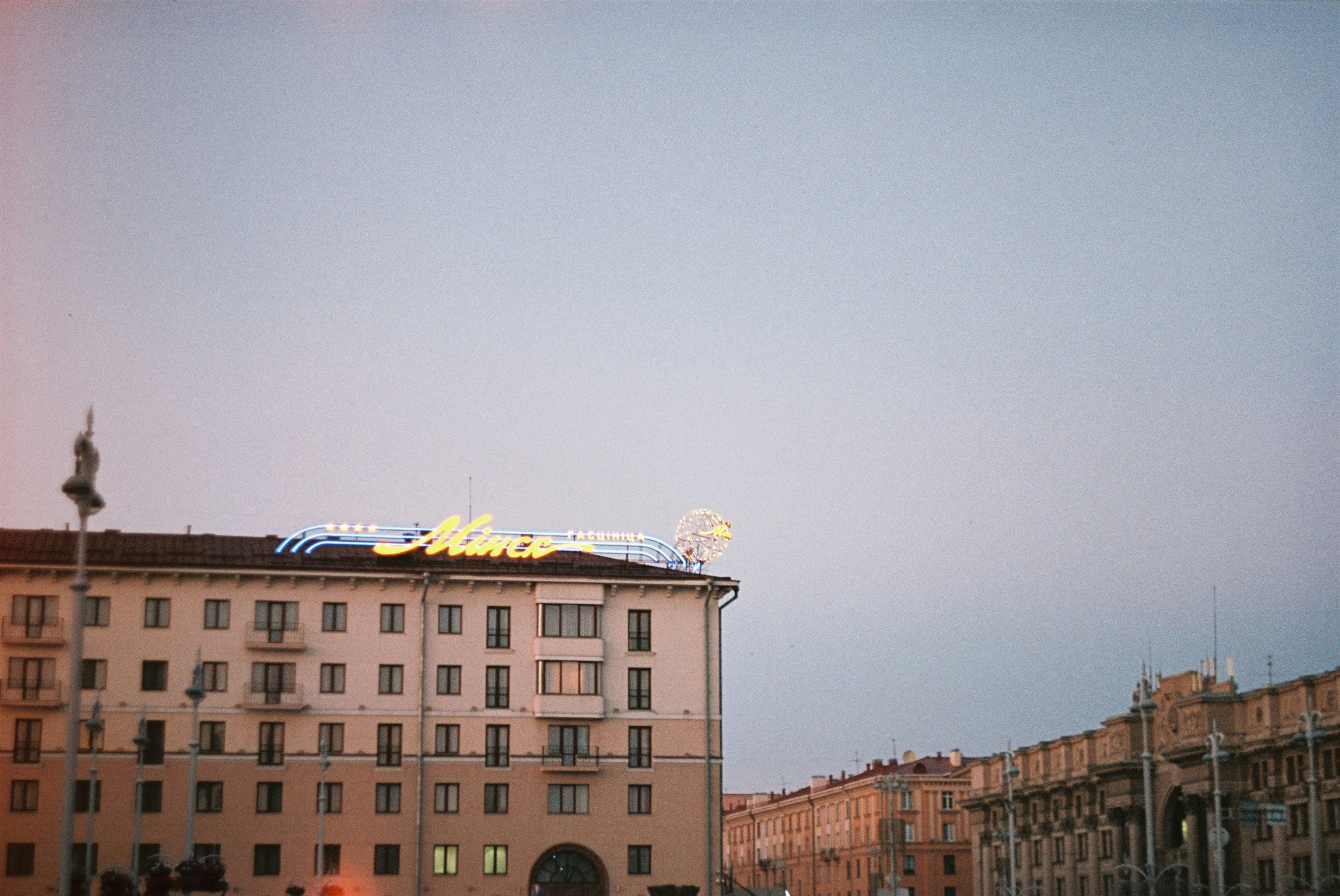 Urban skyline with soft evening light illuminating building tops under a clear sky.