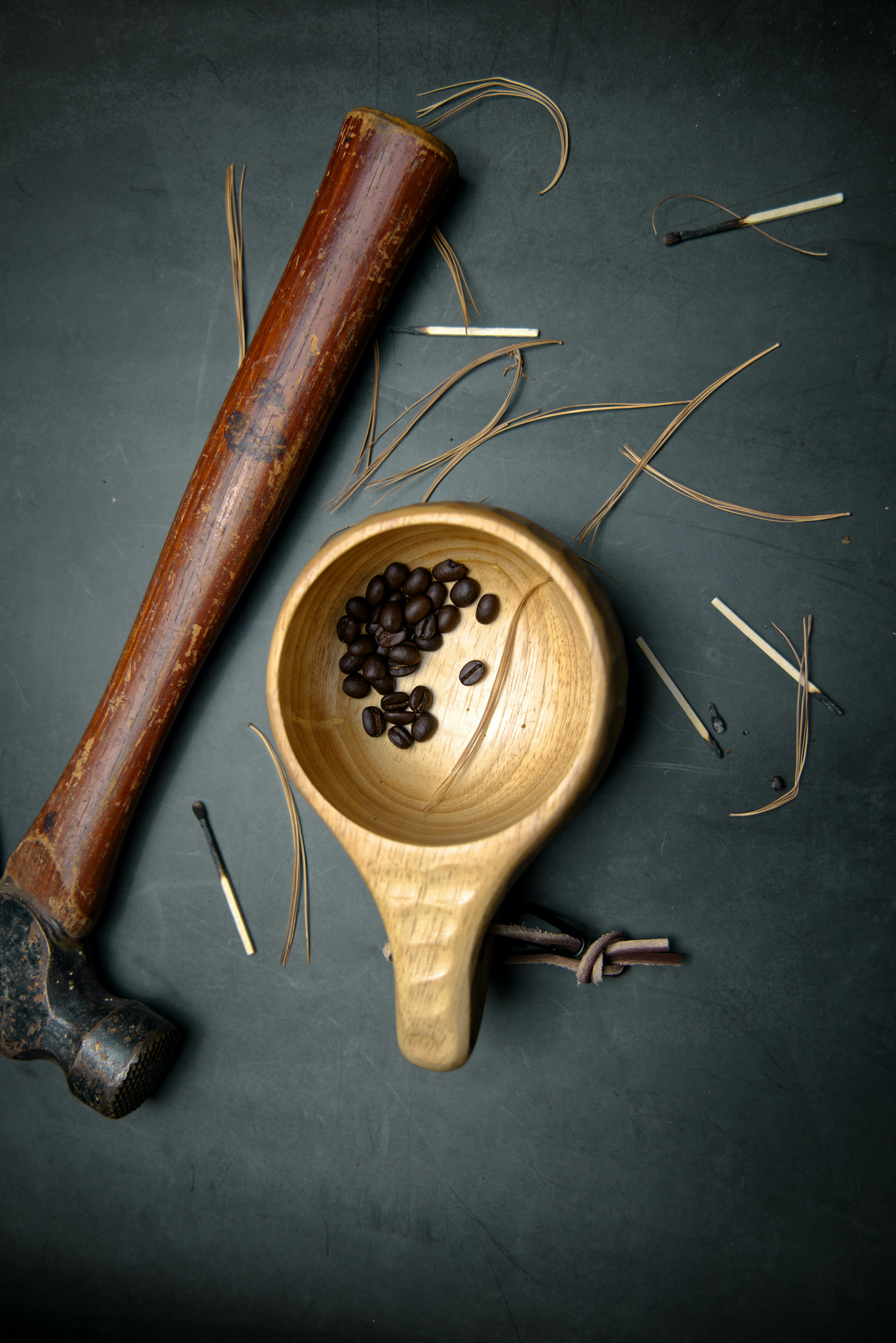 Rustic Still Life: Coffee Beans Cradled in a Wooden Spoon Among Timber Tools