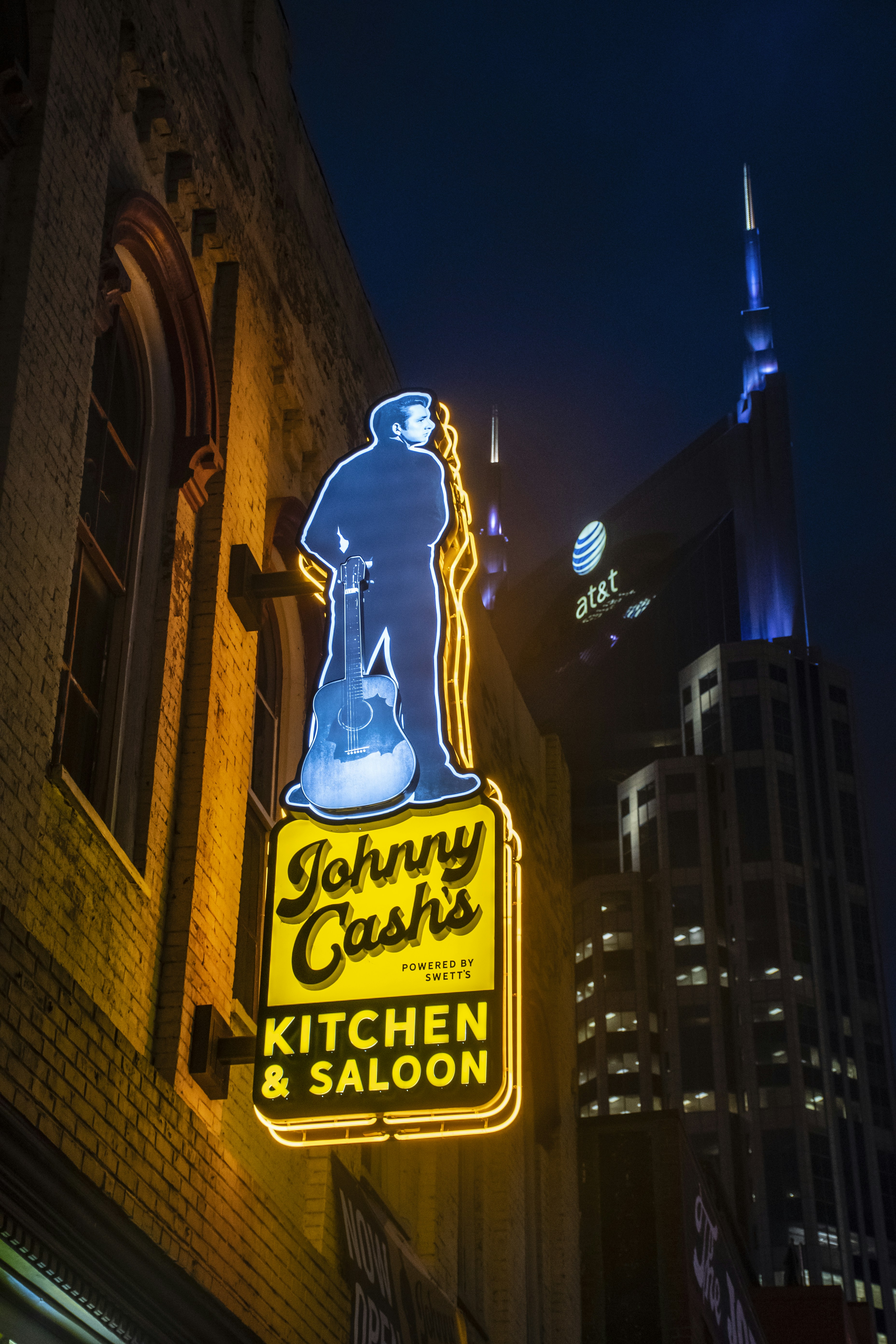 Neon Silhouette Over Brick: Johnny Cash Sign Illuminates a Downtown Night