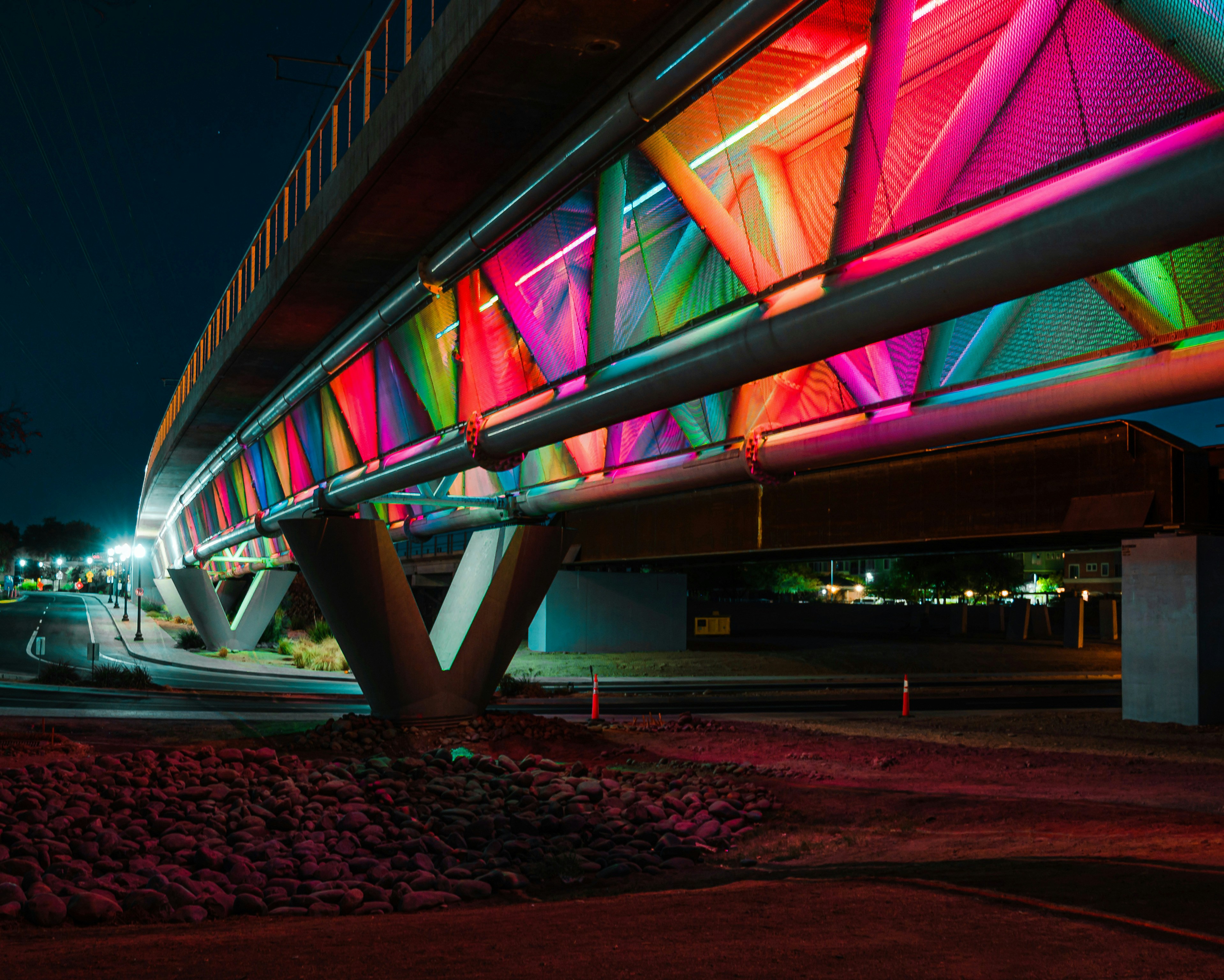 Bridge illuminated with colorful lights in a geometric pattern against the night sky.