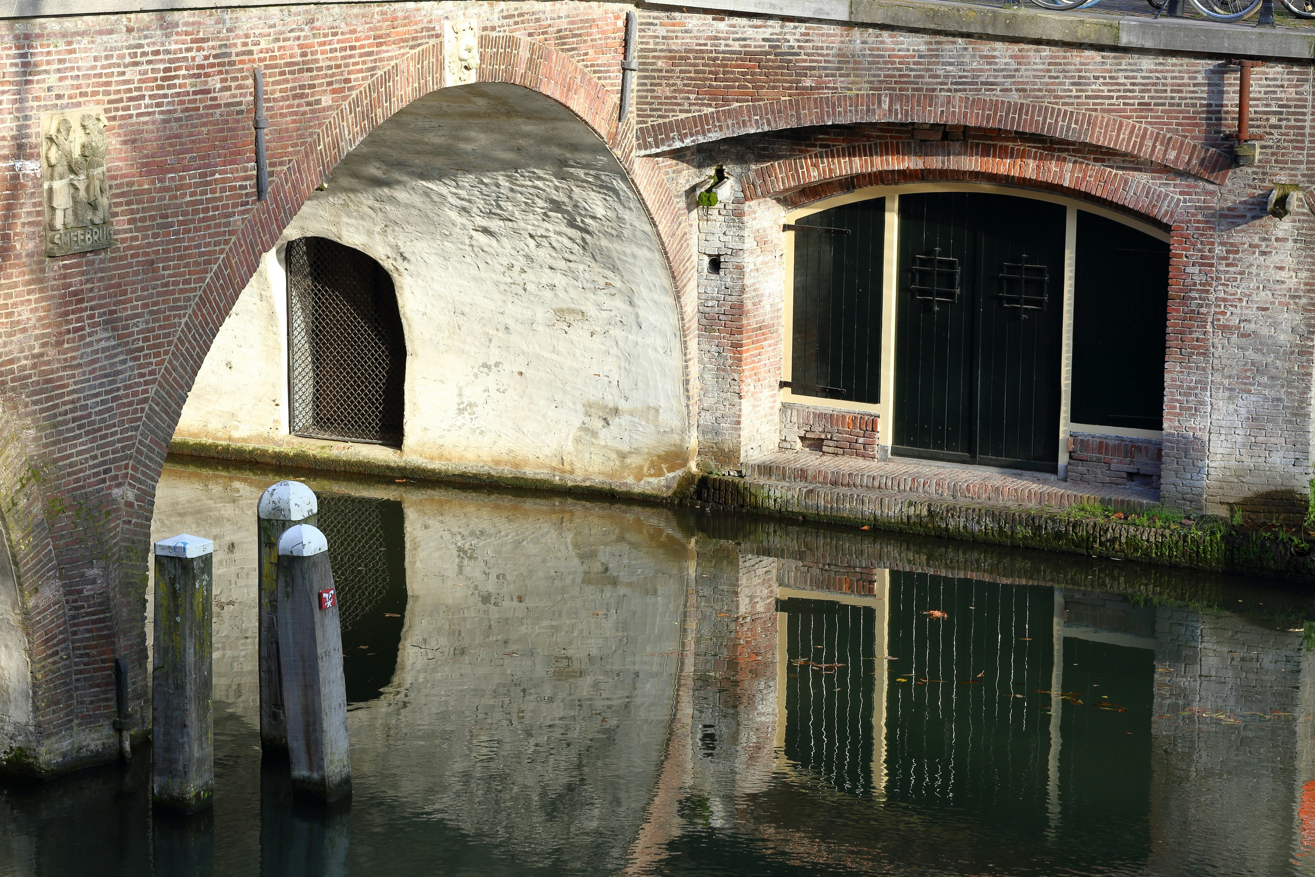 Green Doors Under a Brick Arch: Reflections in a Quiet Canal