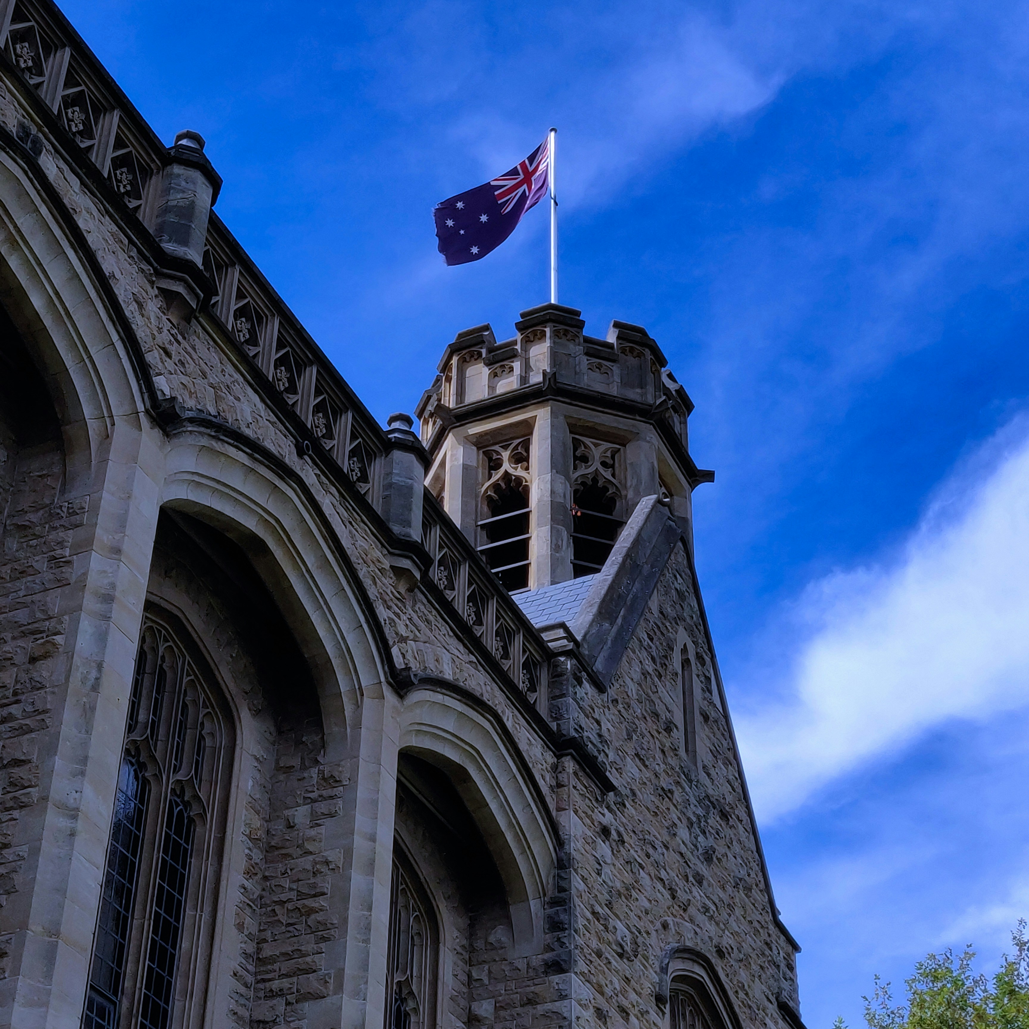 Flag atop a stone turret under a cobalt sky