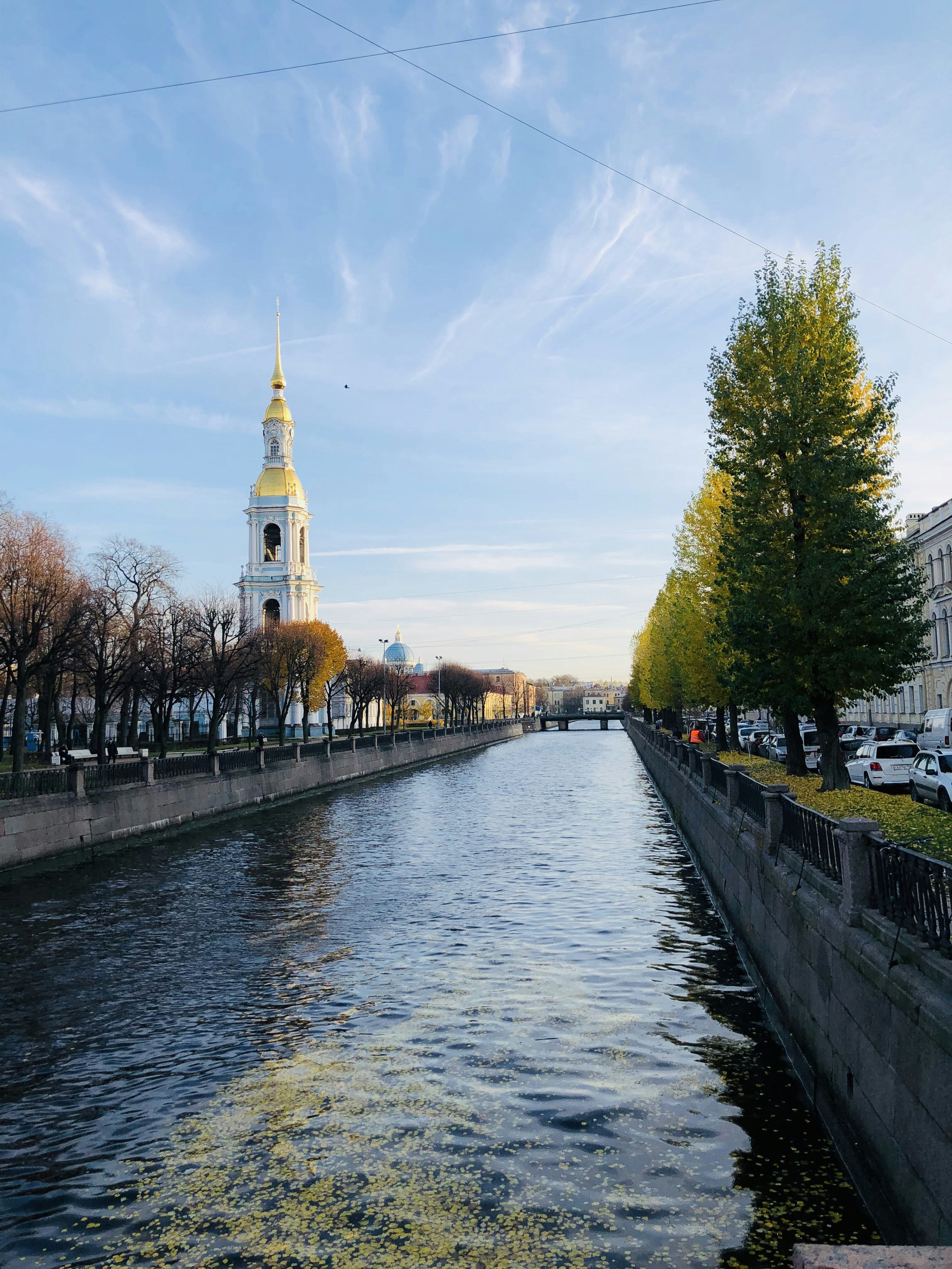 Waterway Through the City: Clock Tower and Autumn Trees Framing a Riverside Canal