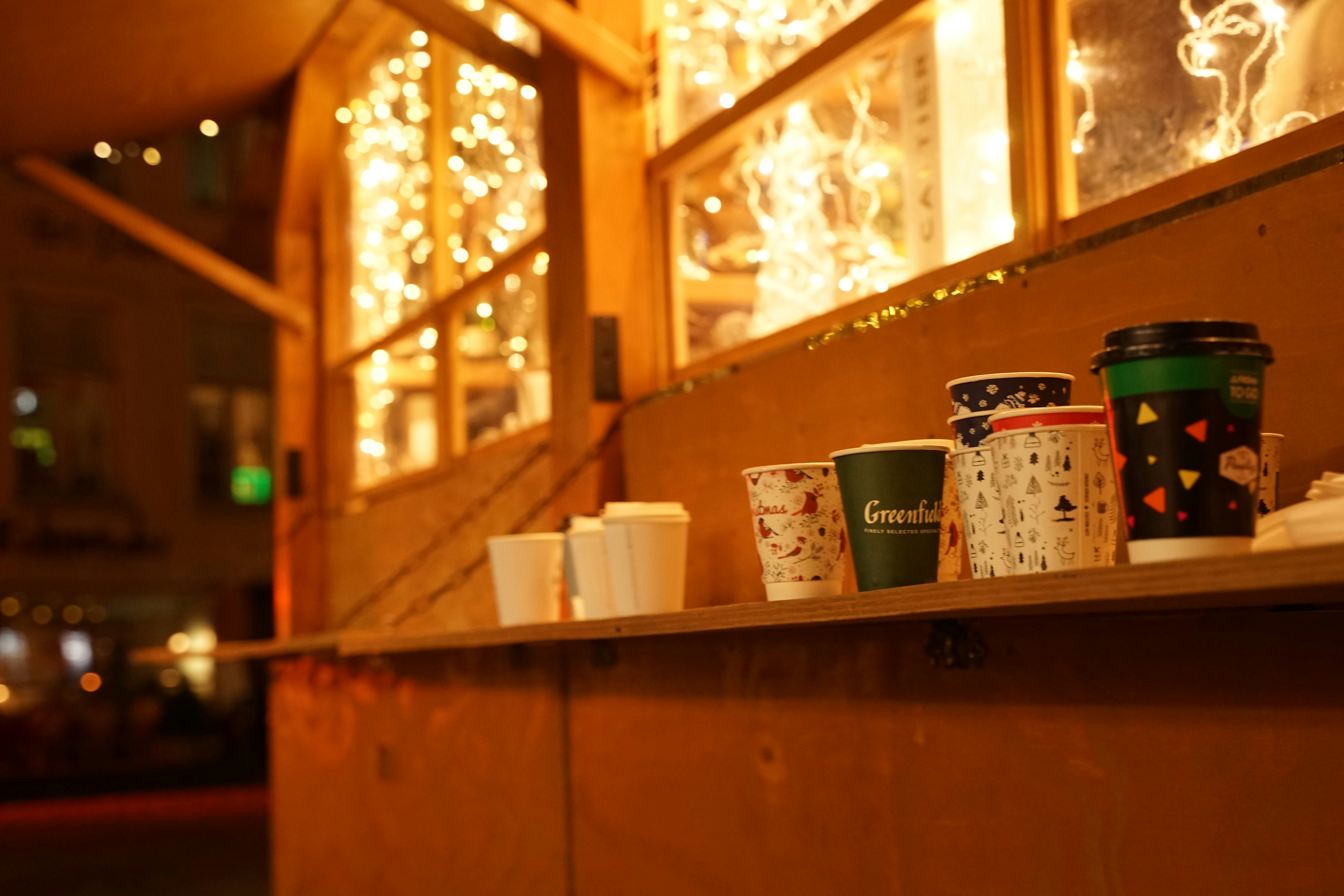 Warm Neon Echoes: Disposable Cups on a Railing