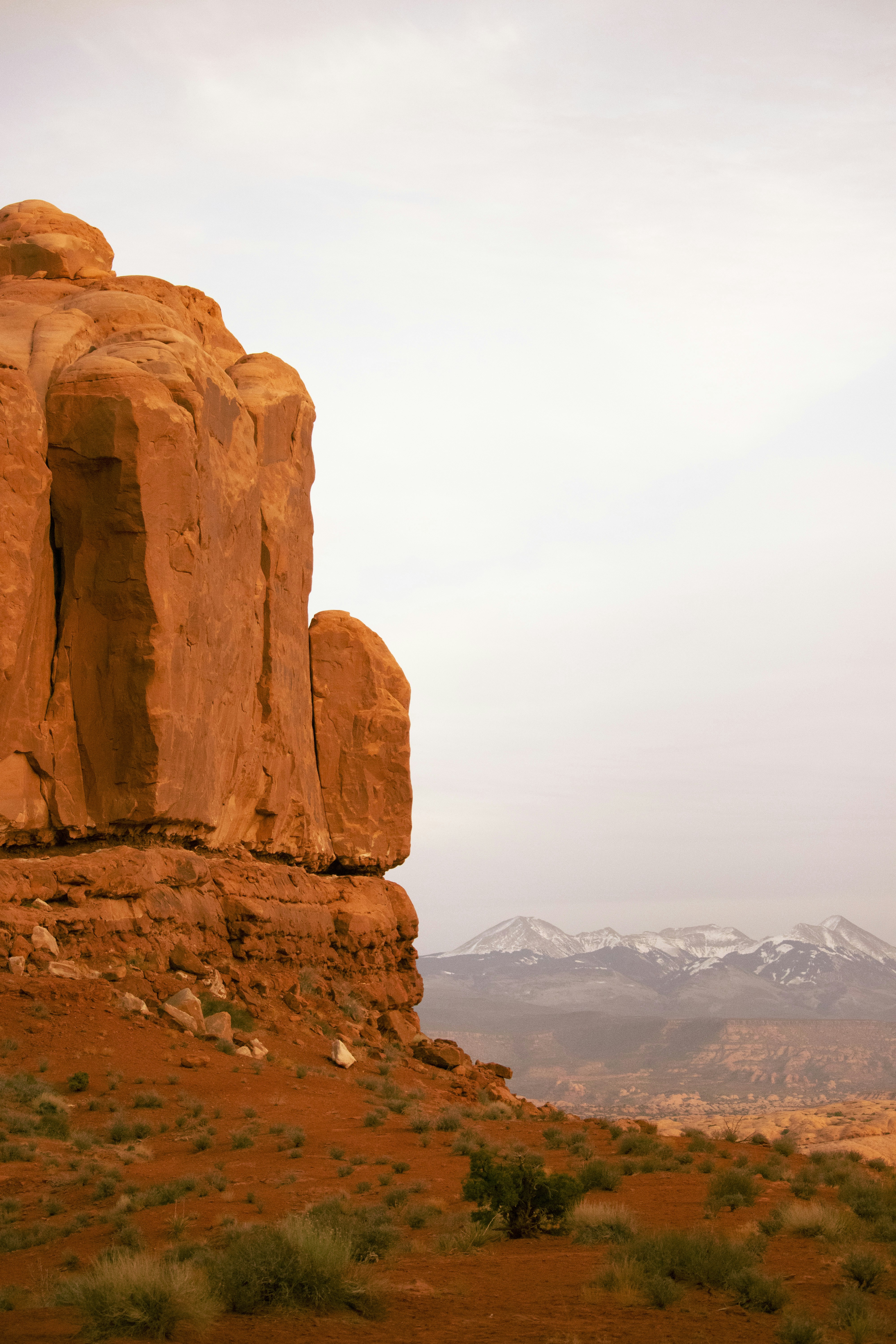 Desert Monolith at Dusk Over Snow-Crowned Peaks