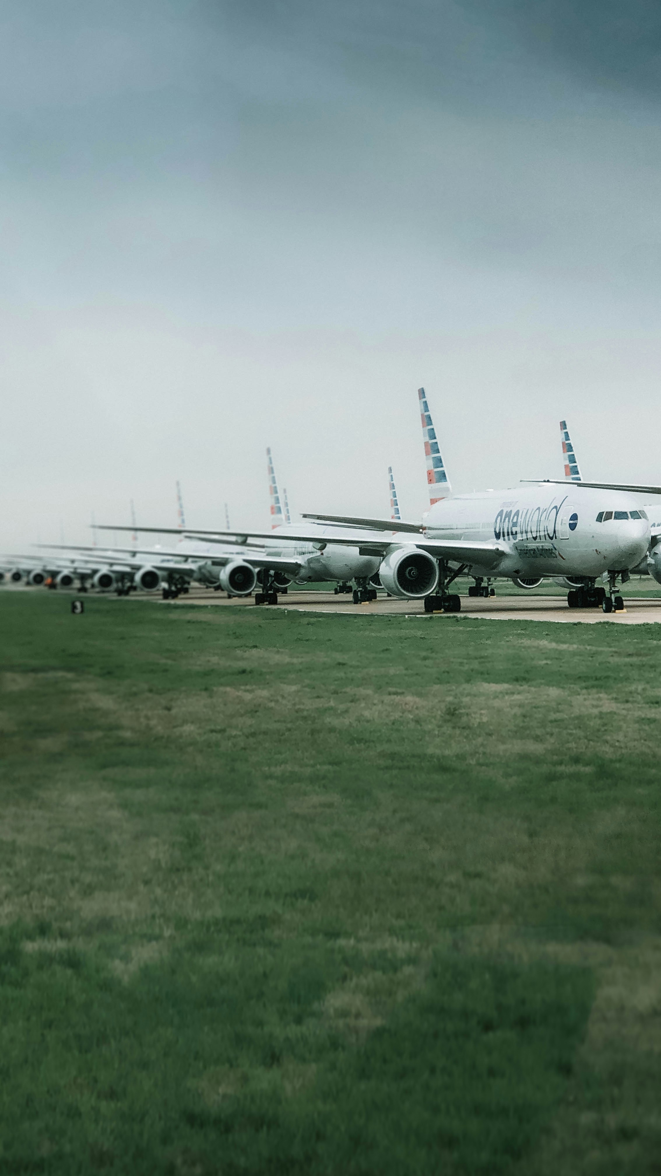 Airplanes during American lockdown | white passenger plane on green grass field during daytime