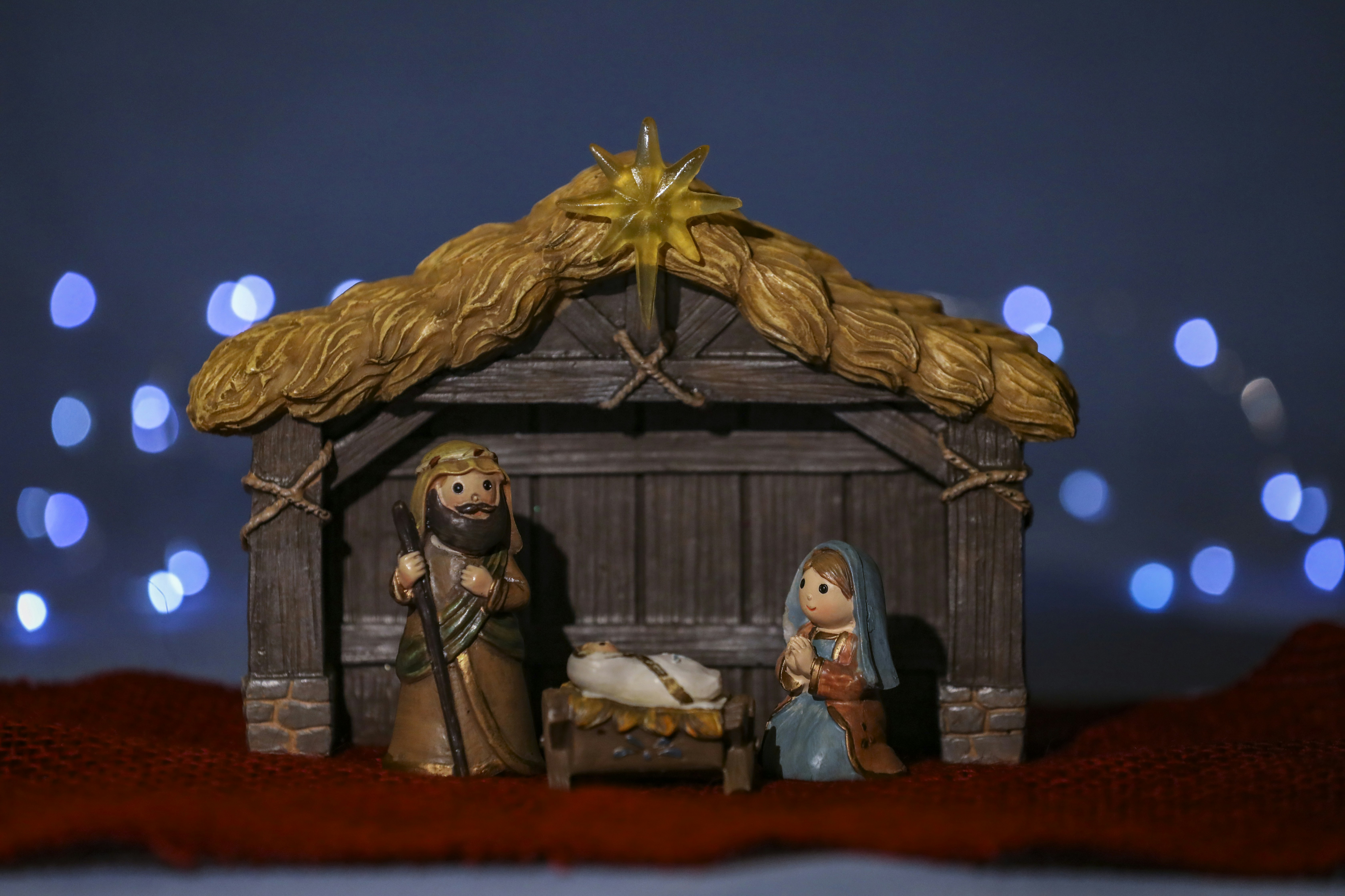 A charming nativity scene featuring Mary, Joseph, and the baby Jesus, set against a backdrop of soft, glowing lights.