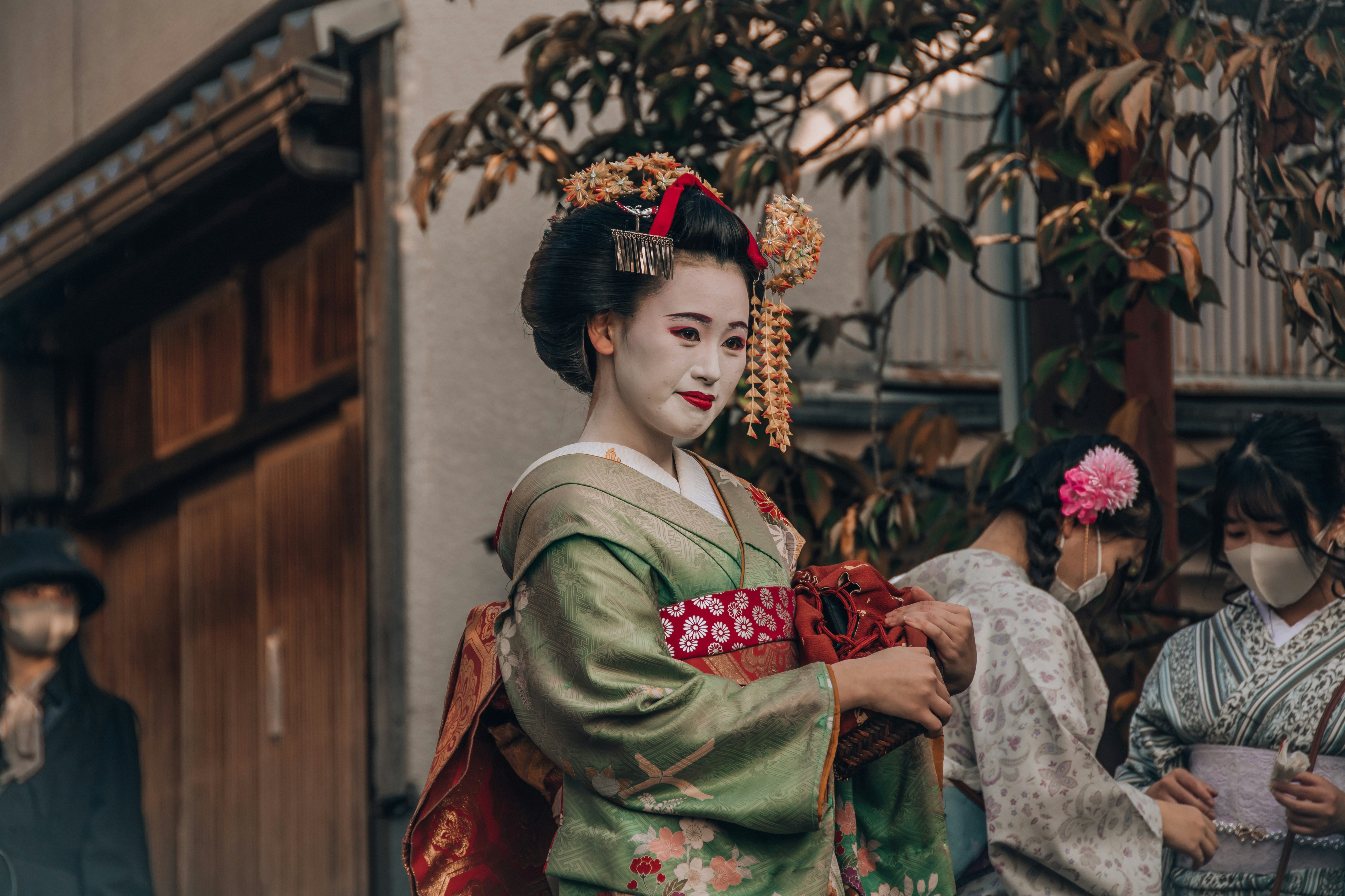Geisha adorned in traditional attire, showcasing intricate details and cultural heritage amidst a bustling background.