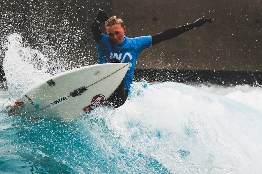Surfer in a blue and white wetsuit skillfully navigating a wave with a white surfboard.