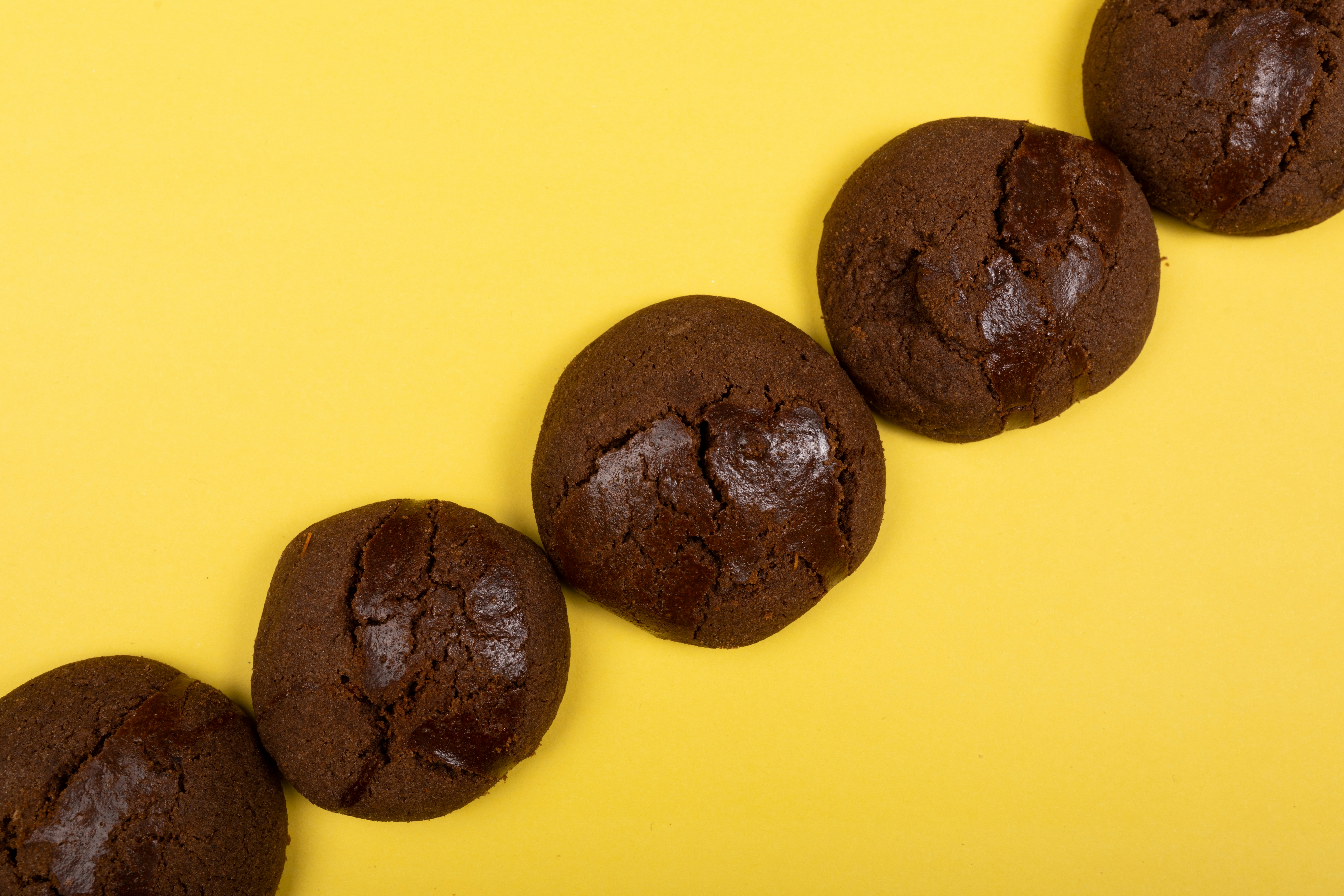 Biscuits ronds noirs sur surface jaune photo – Photo Brun Gratuite sur ...